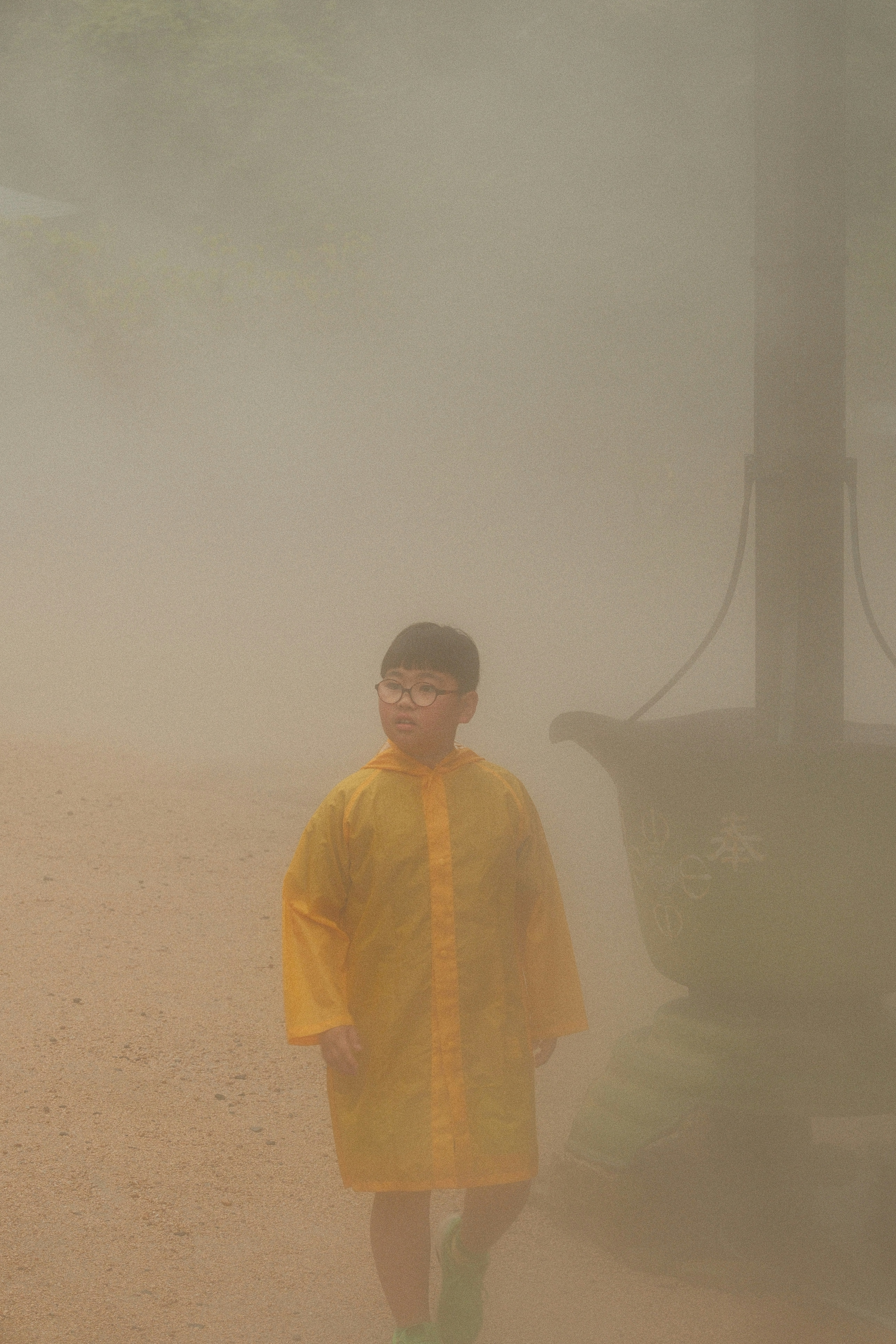 Mist Over the Semaphore: A Child in a Bright Yellow Rain Poncho