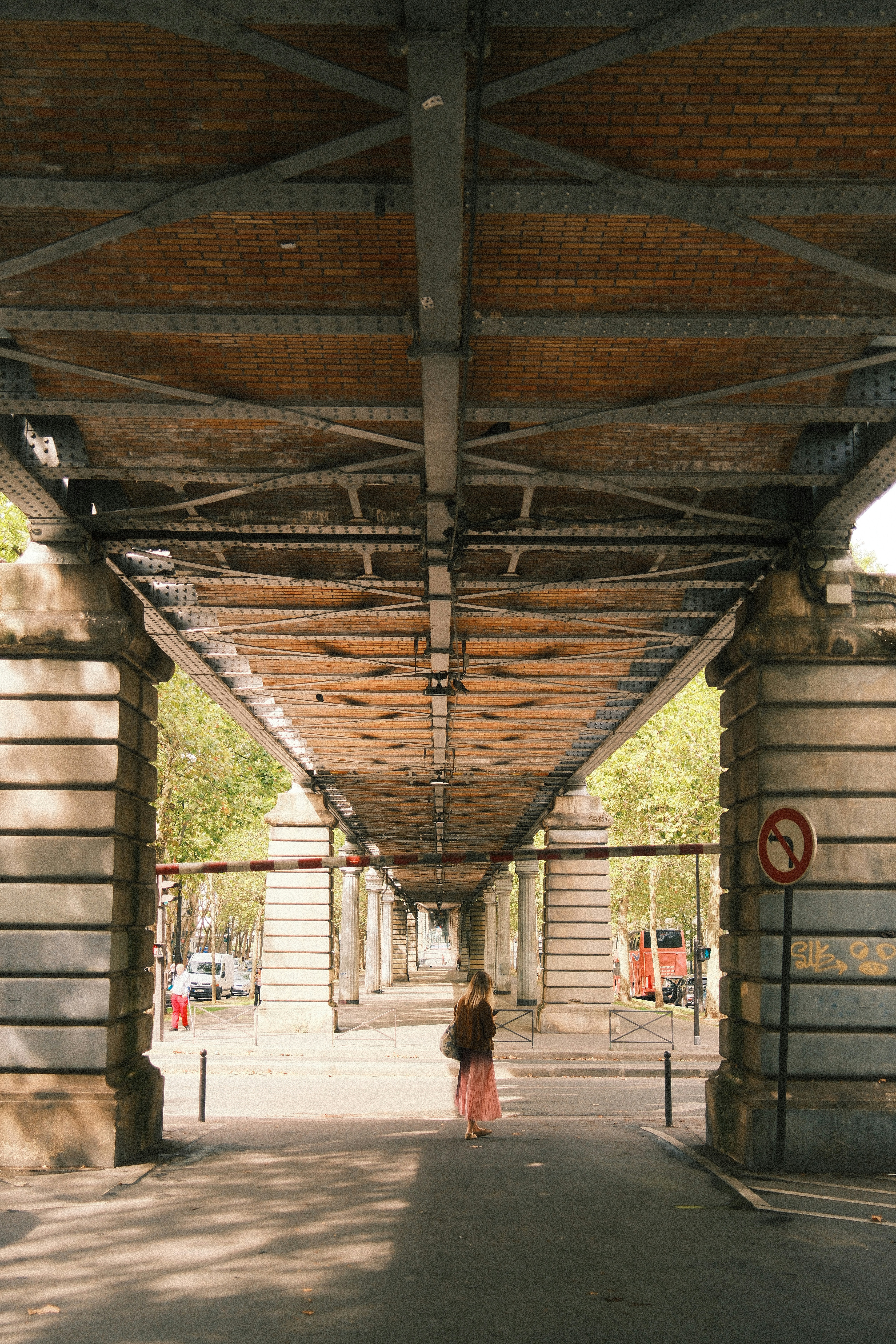 Under the Brick Arches: A lone figure walking toward endless perspective