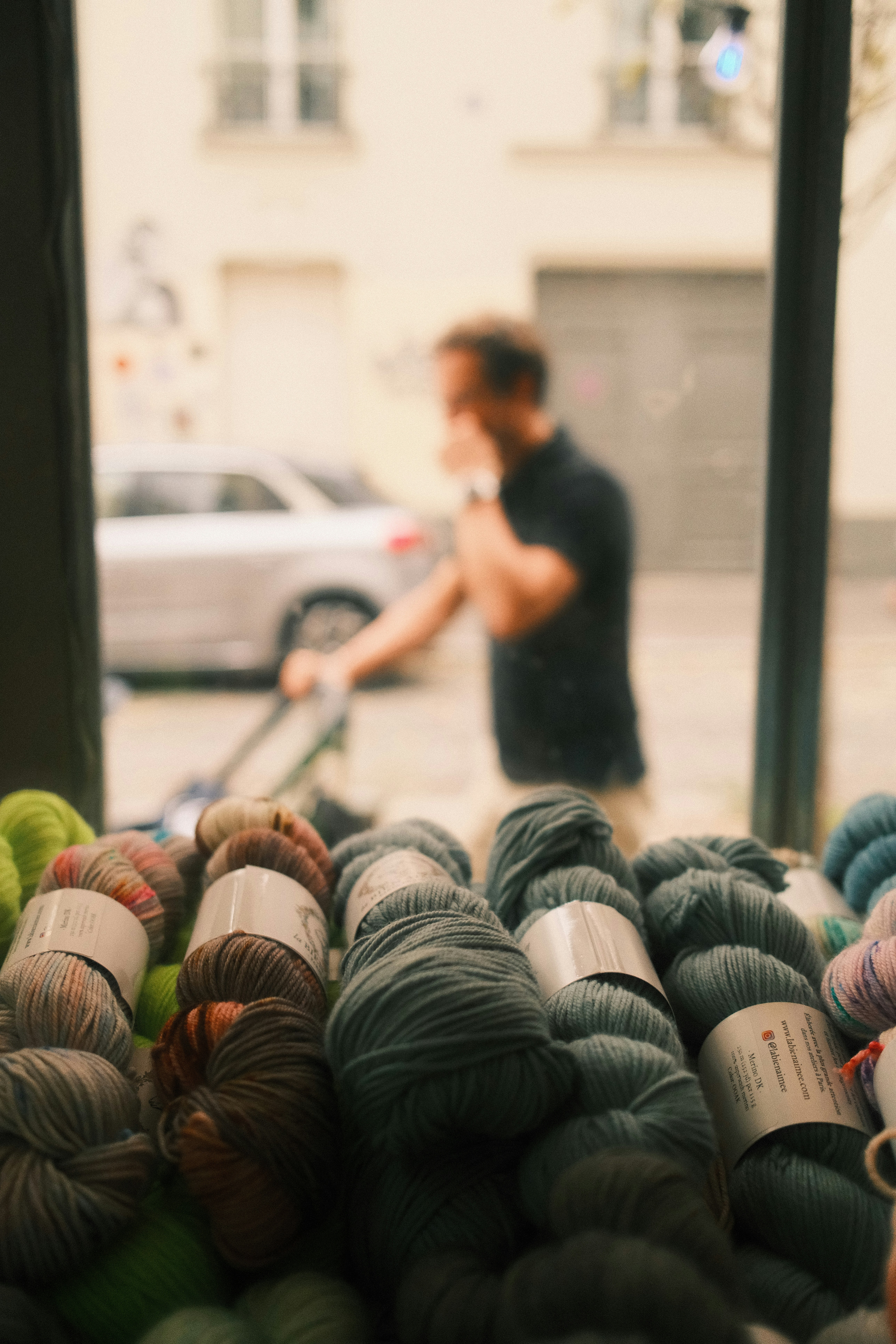 Threads of Color: A Yarn Shelf Framing a Quiet Street