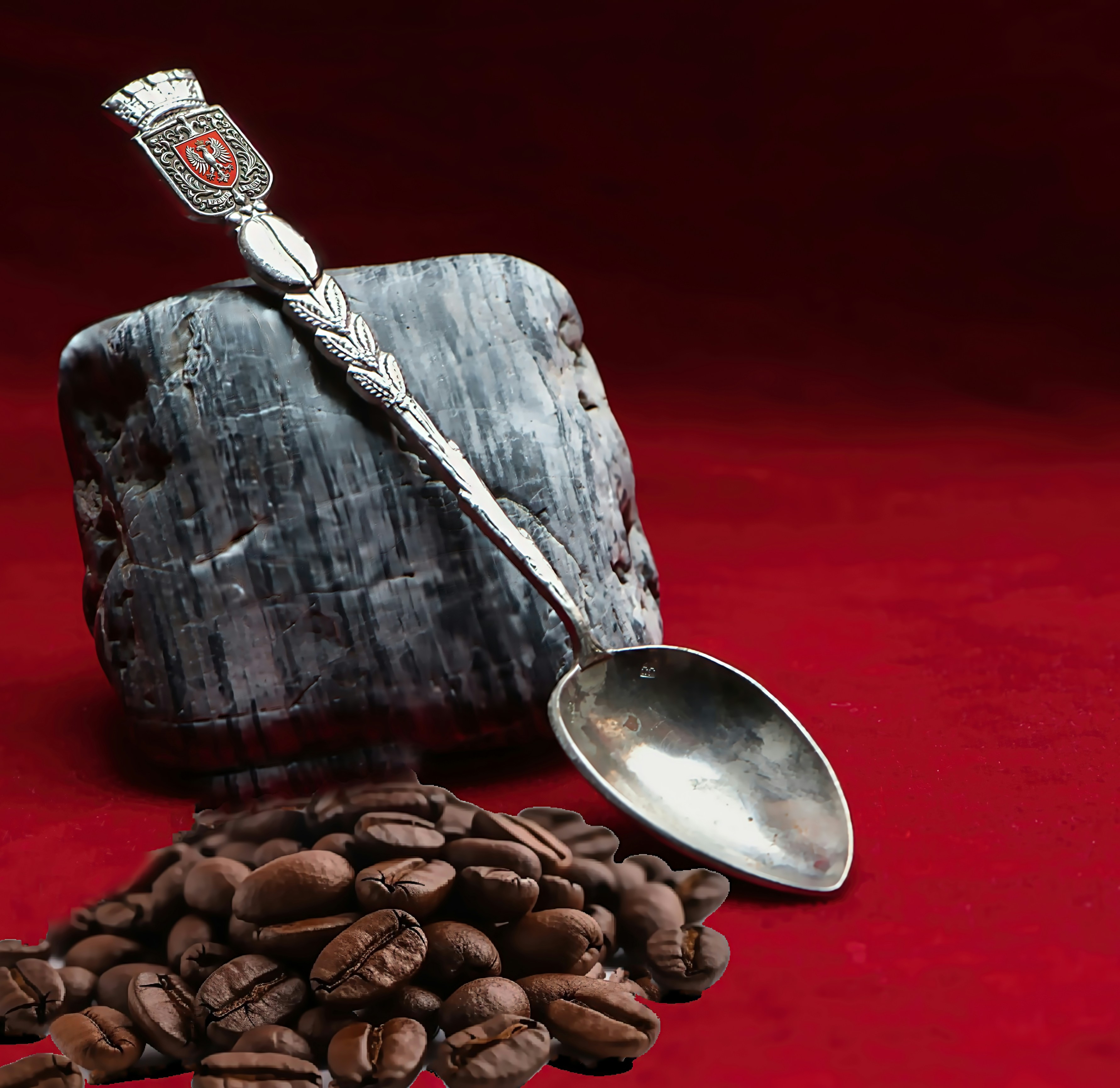 Spoon over a pile of beans against a ruby velvet backdrop