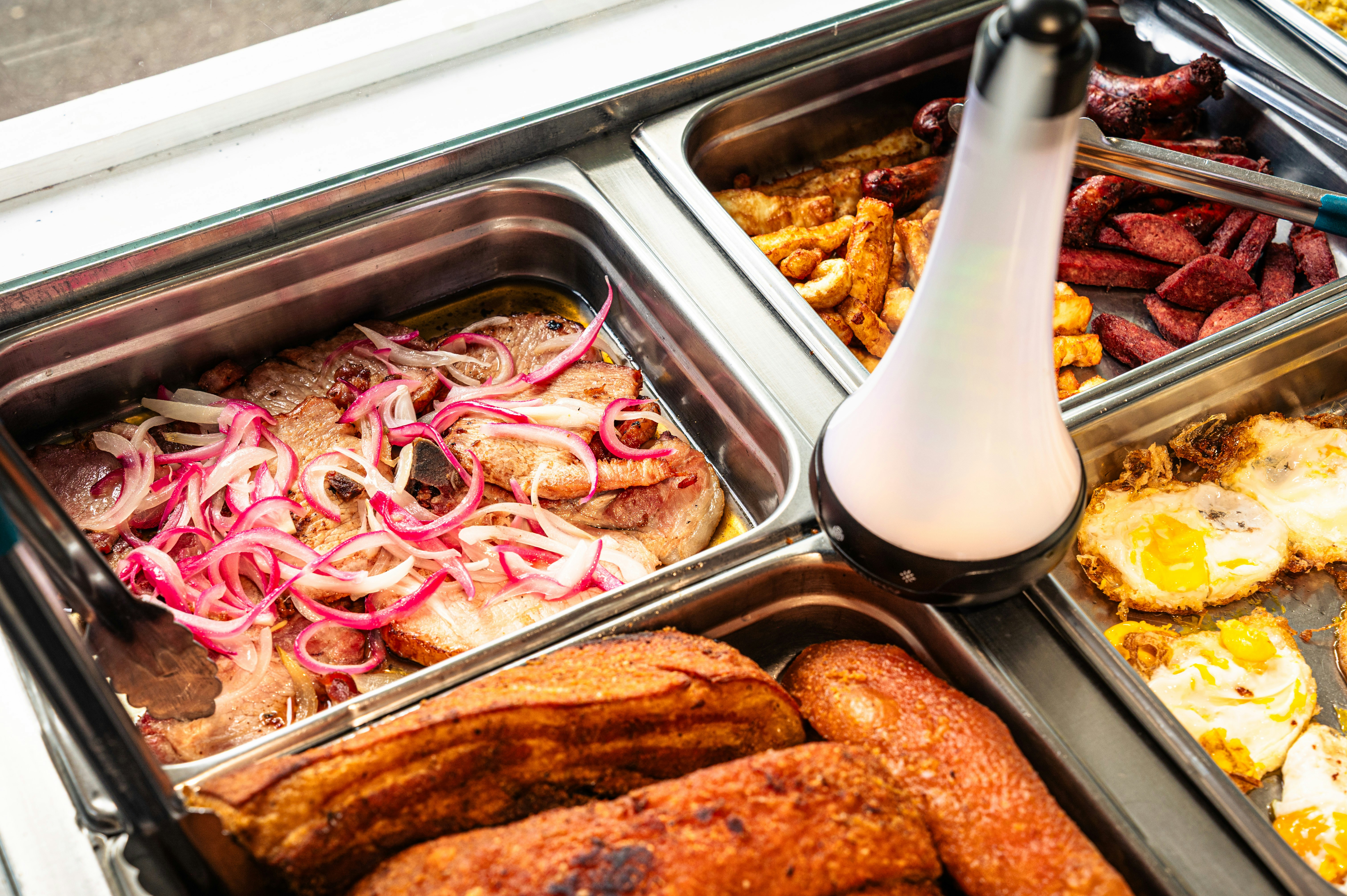 Sauces and Sizzle: A Tapas of Warm Deli Dishes in Metal Trays