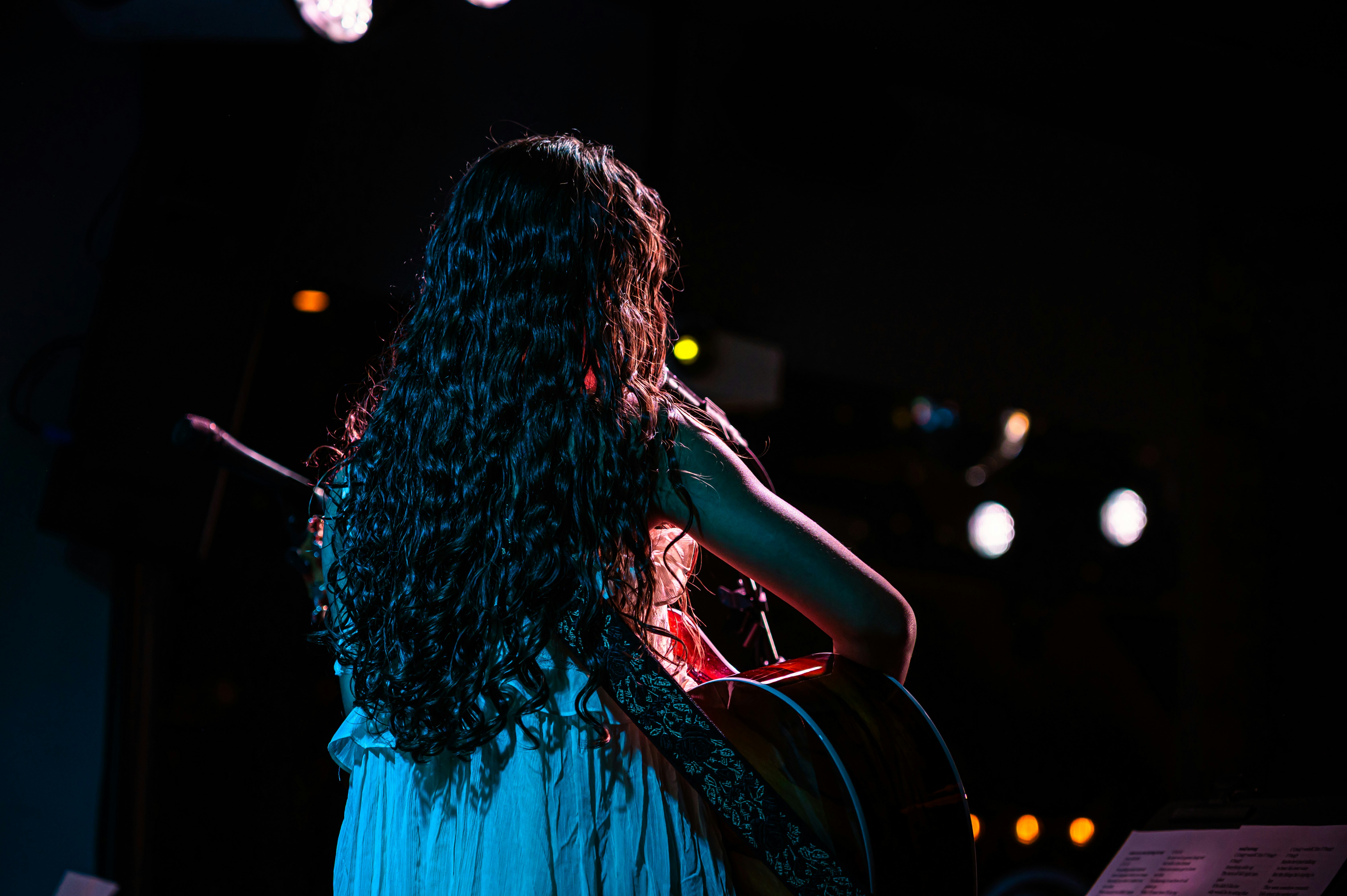 Backlit Strings and Shifting Silhouette: A Guitarist in Deep Blues