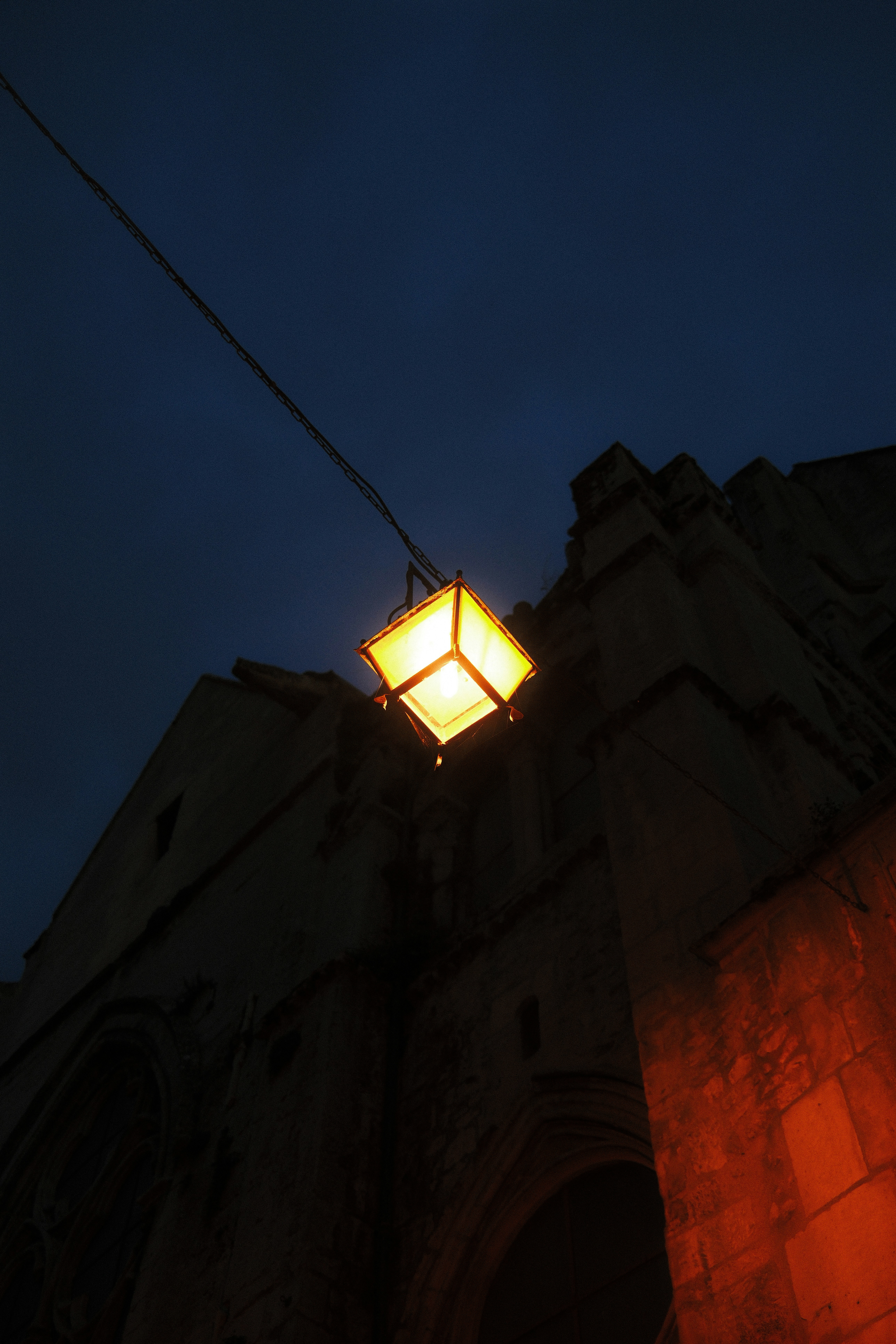 Lantern in the Dark: A Corner of Light on a Gothic Facade
