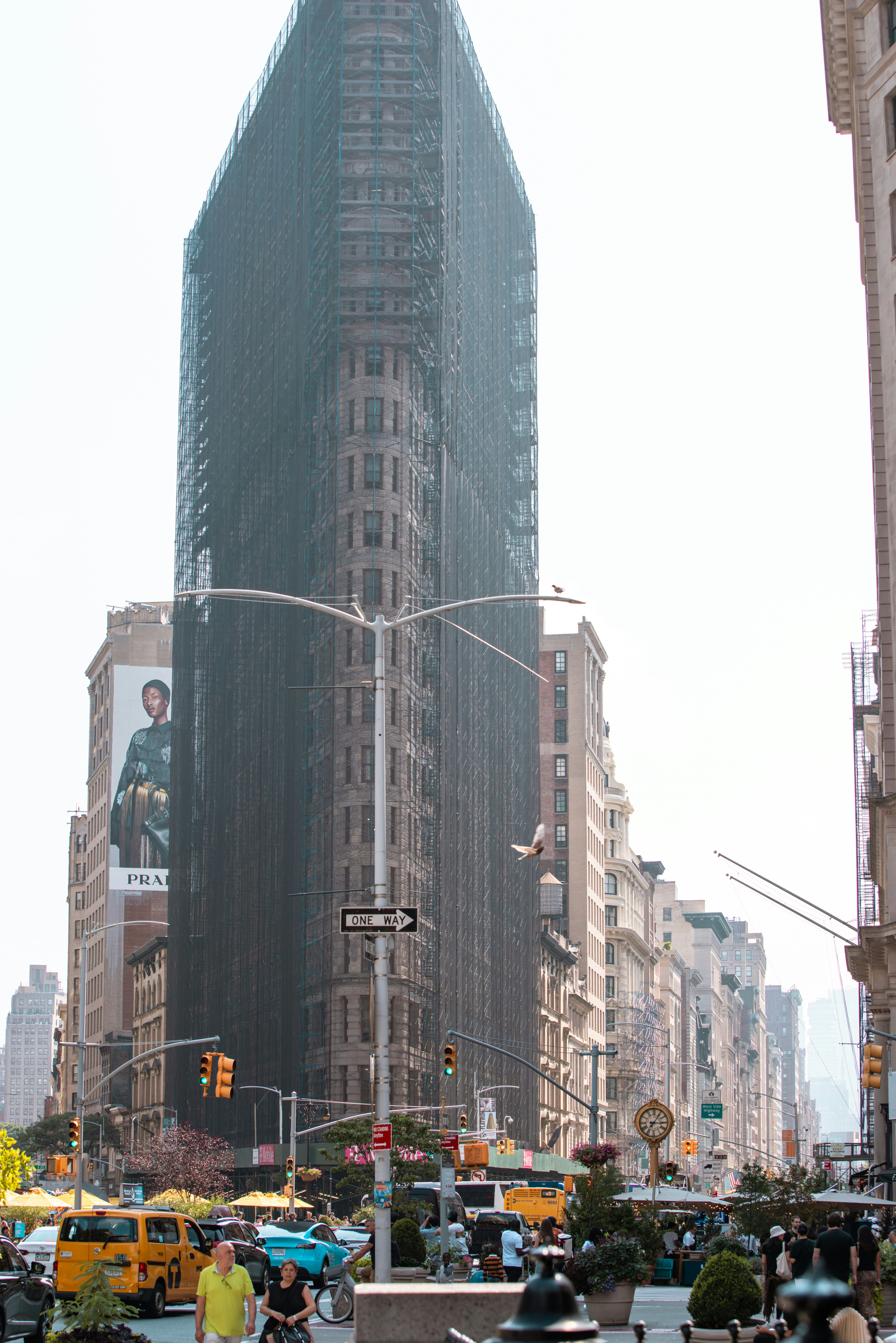 Towering Skeleton: A Scaffolded Edifice Dominates a Bustling Midtown Street