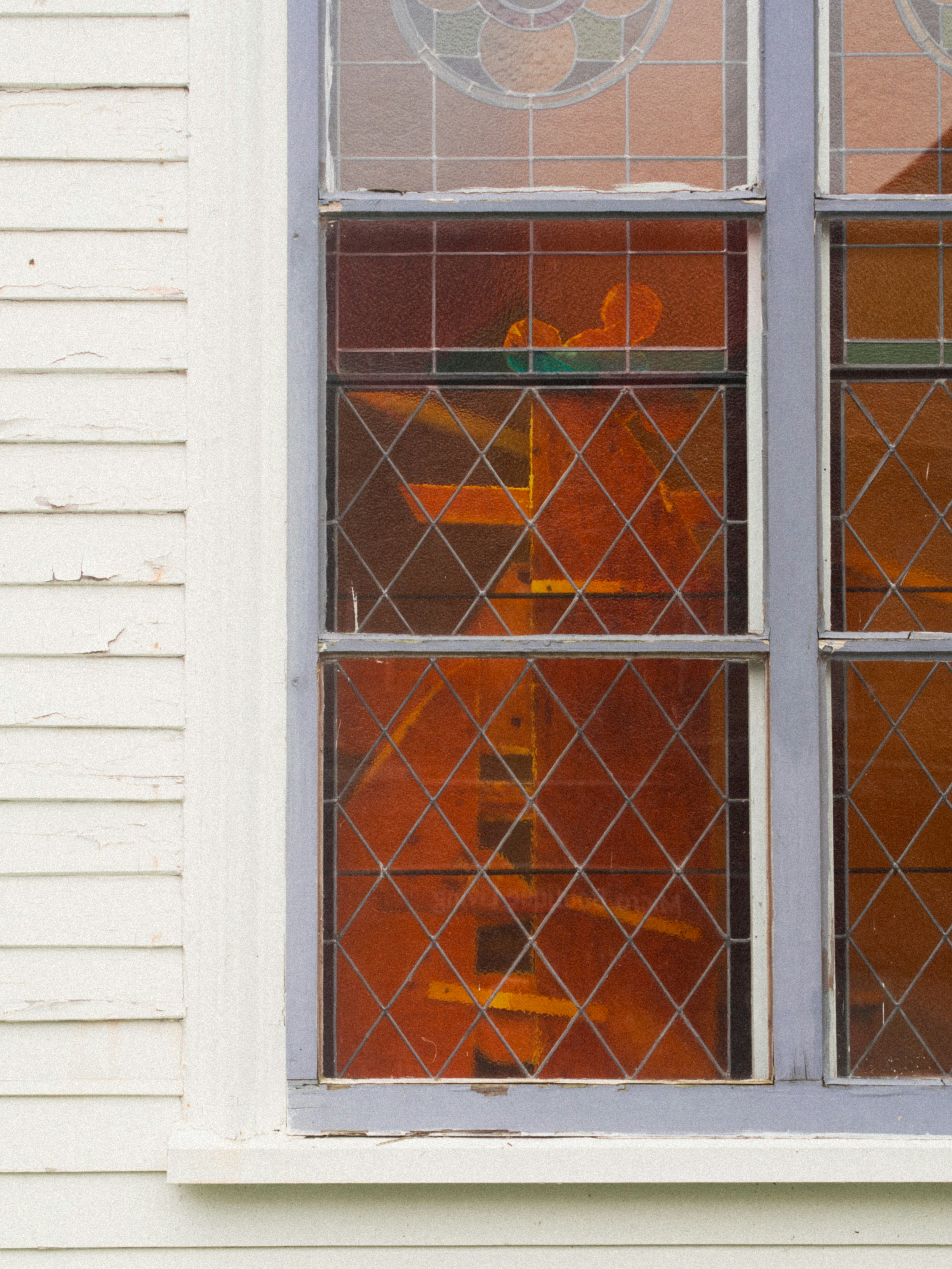 Stained Glass Grid Behind Glass: Warm Ambience in an Old Window
