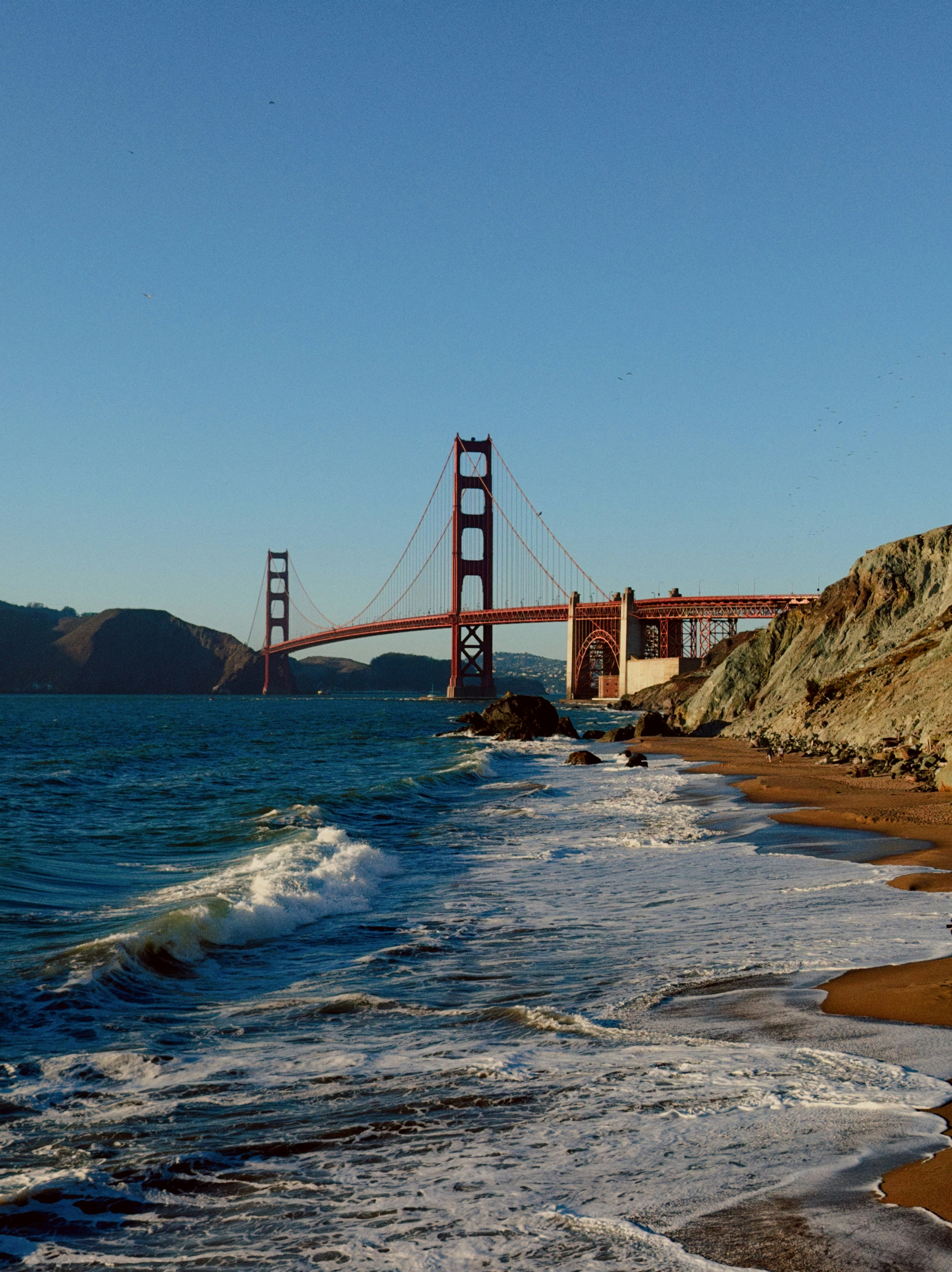 Golden Gate Quiet: Water, Rock, and Bridge in Golden Light