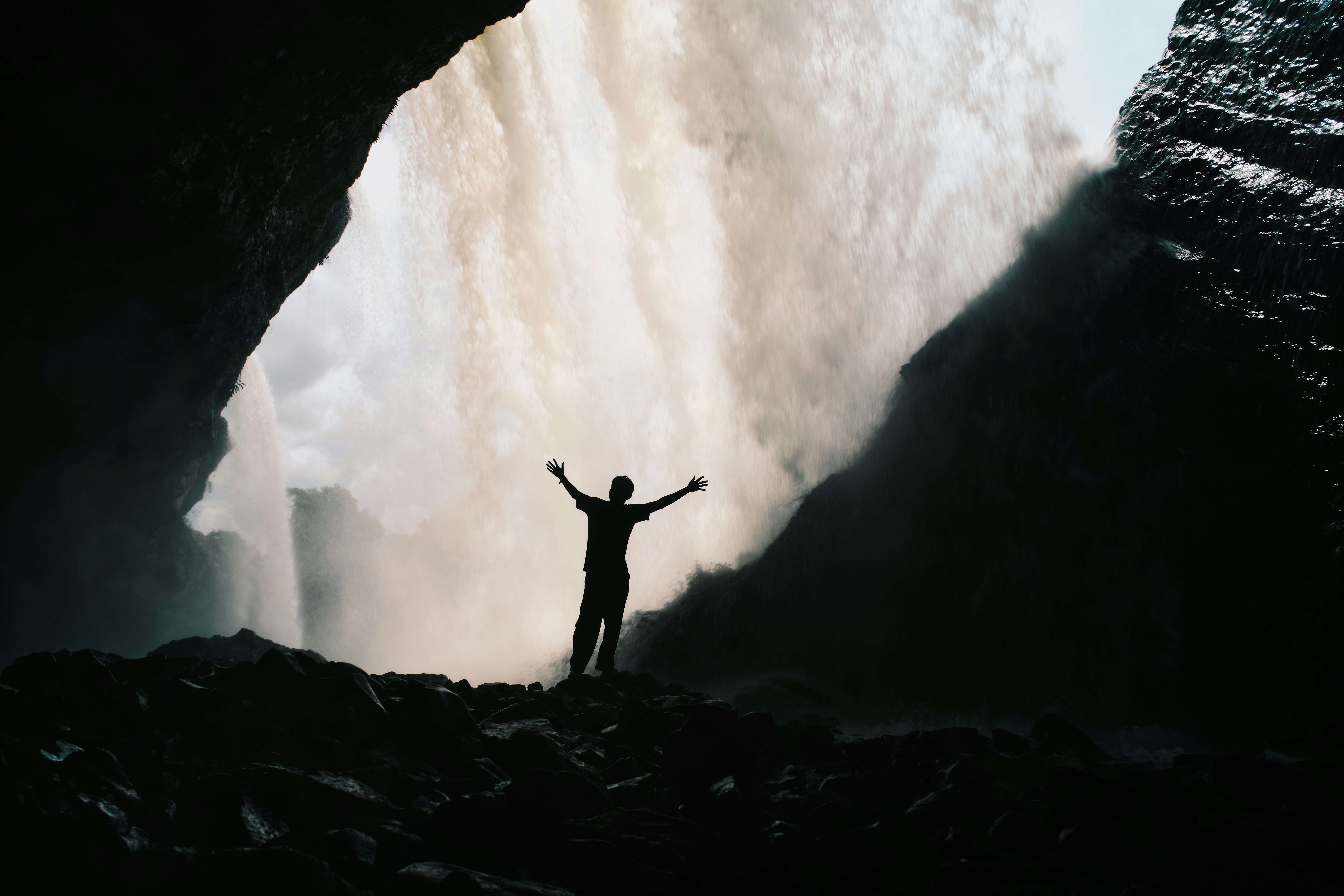 Silhouette of Triumph Before a Titan Waterfall