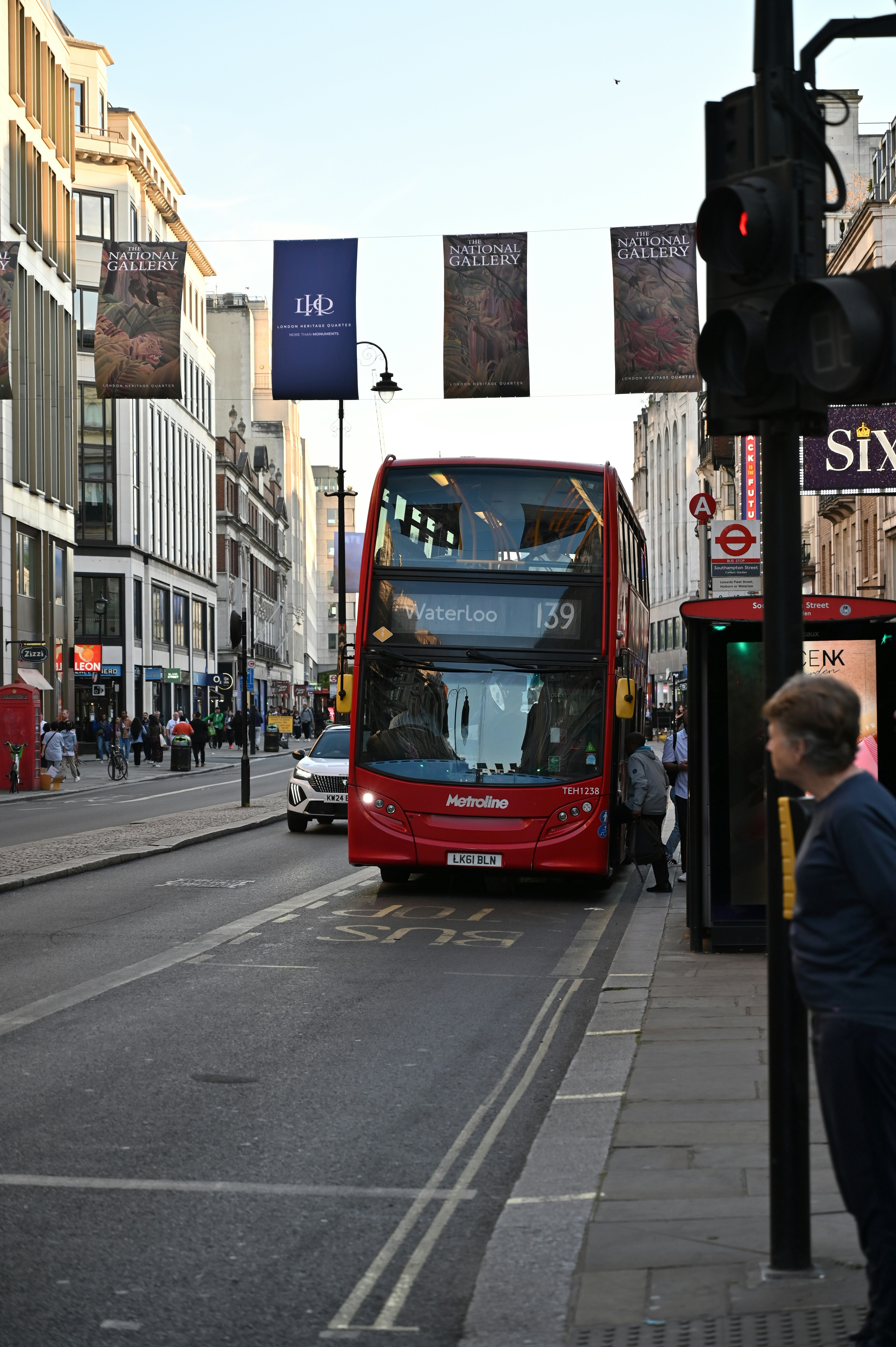 Red Double-Decker on a London Street Under Bannered Sky