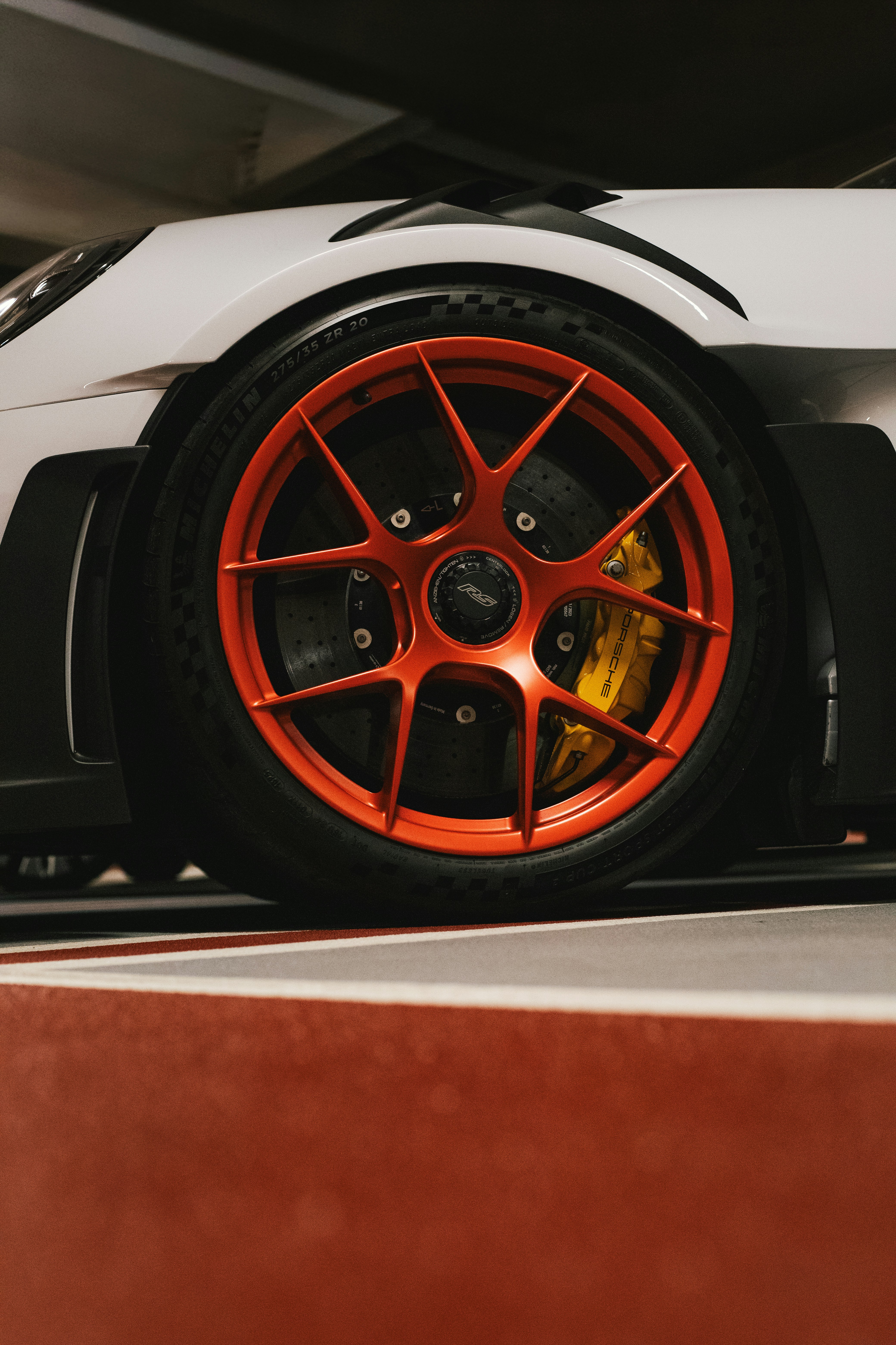 Crimson Spokes: A Close-Up on the Racing Wheel and Brake Caliper