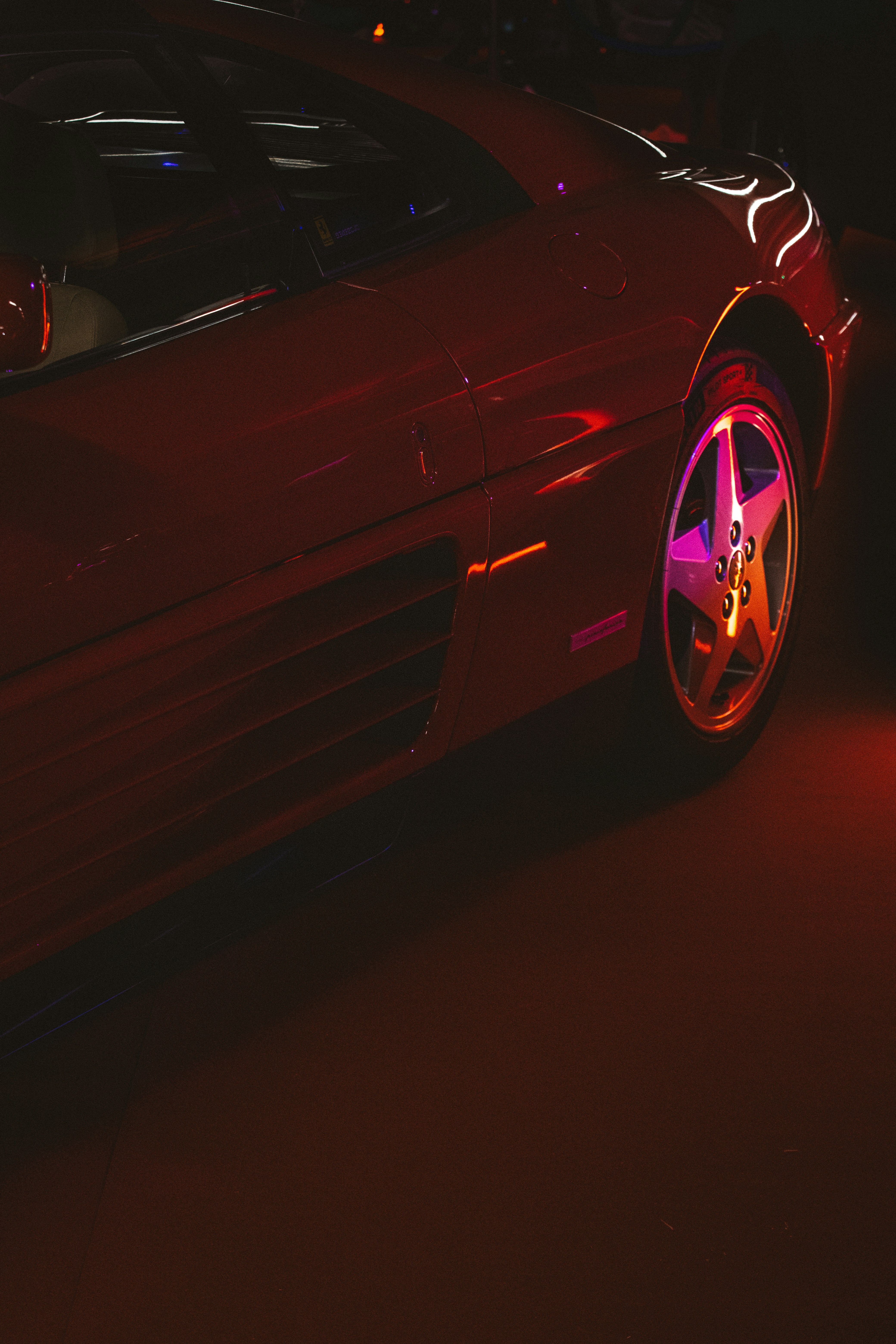 Midnight Red: Neon reflections on a parked sports coupe