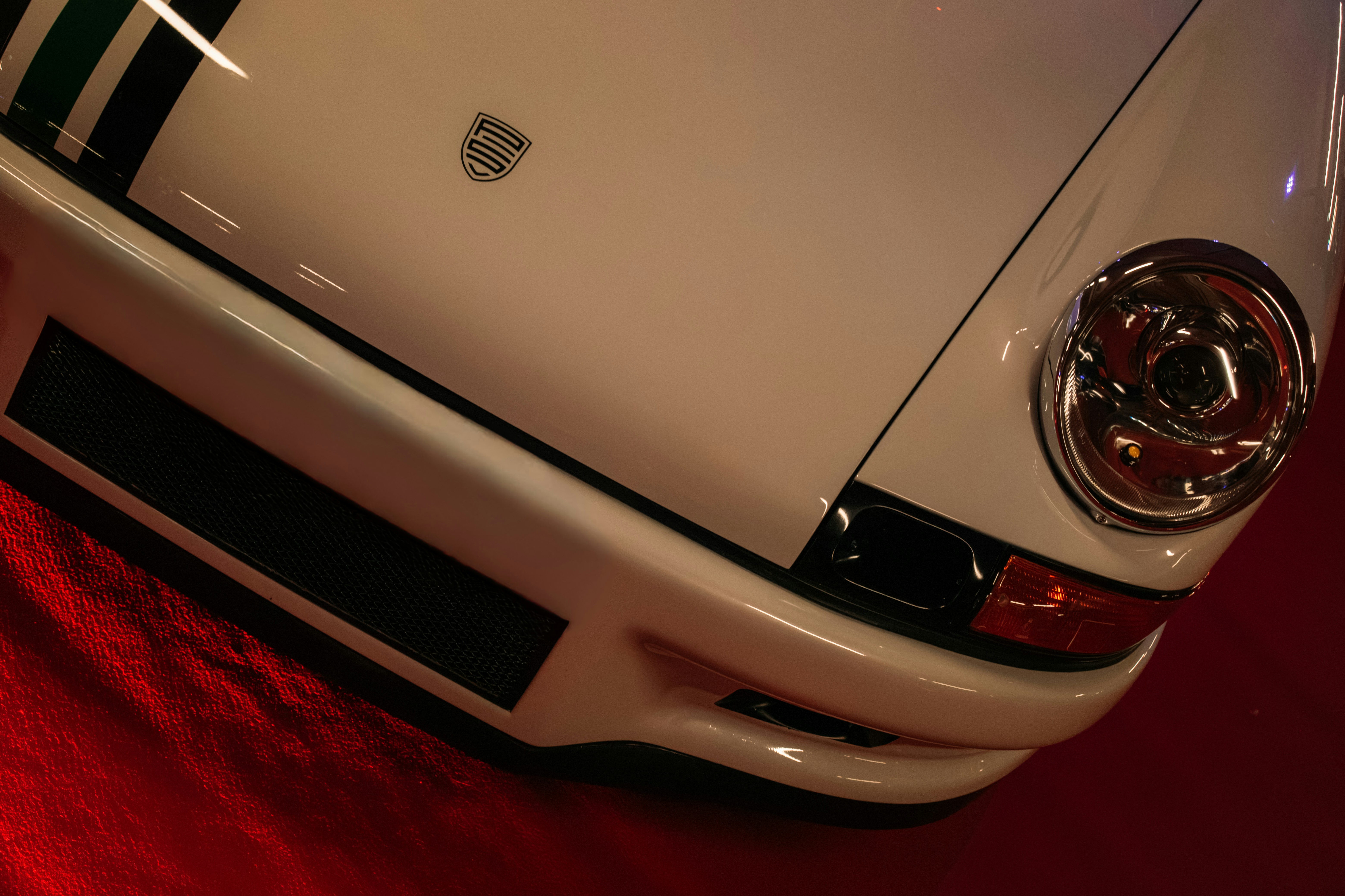 Low-Angle Portrait of a Classic Porsche Nose Resting on Velvet Red Stage
