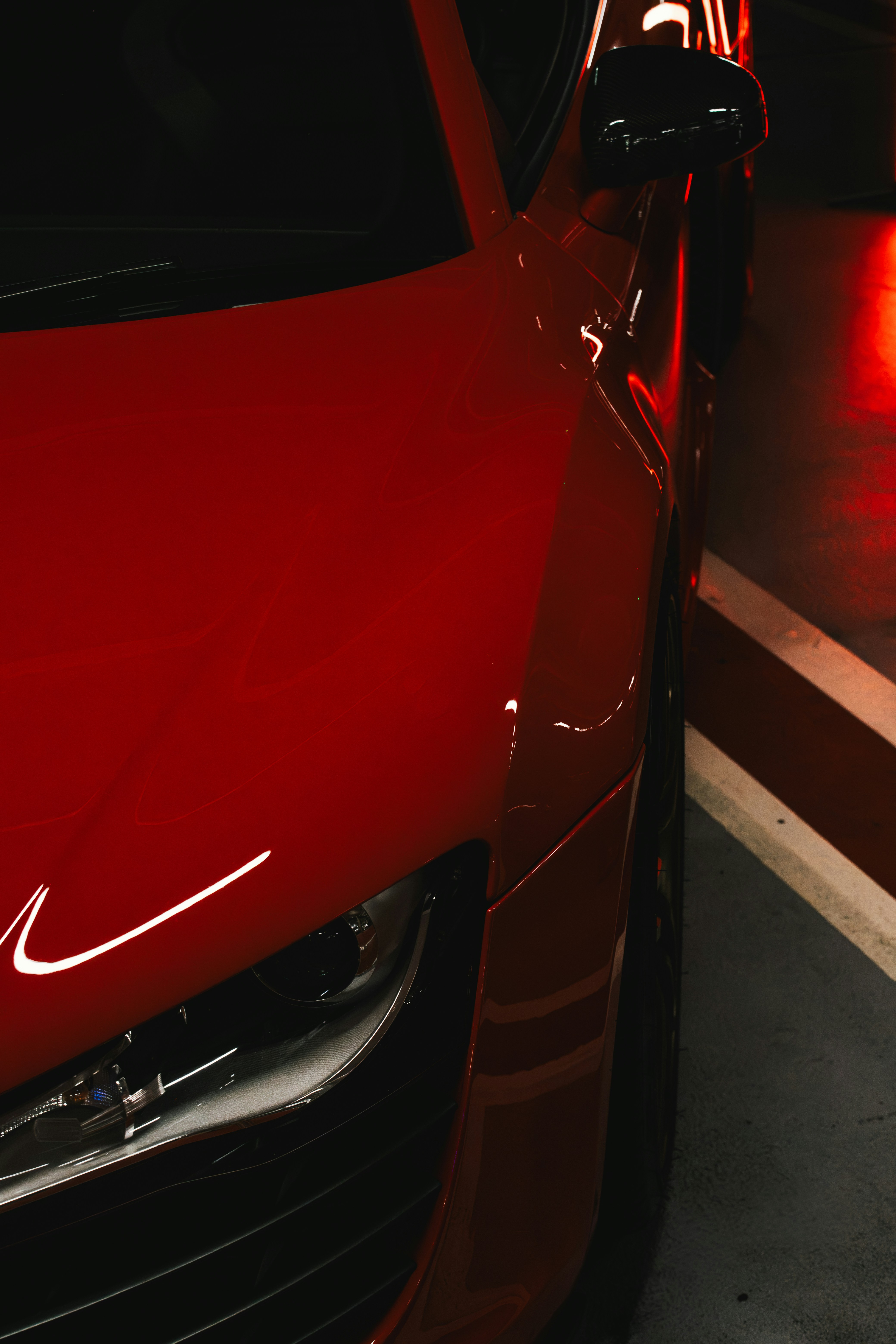 Red Streak: A Close-Quarter Glimpse of a Sporty Red Car's Front Quarter