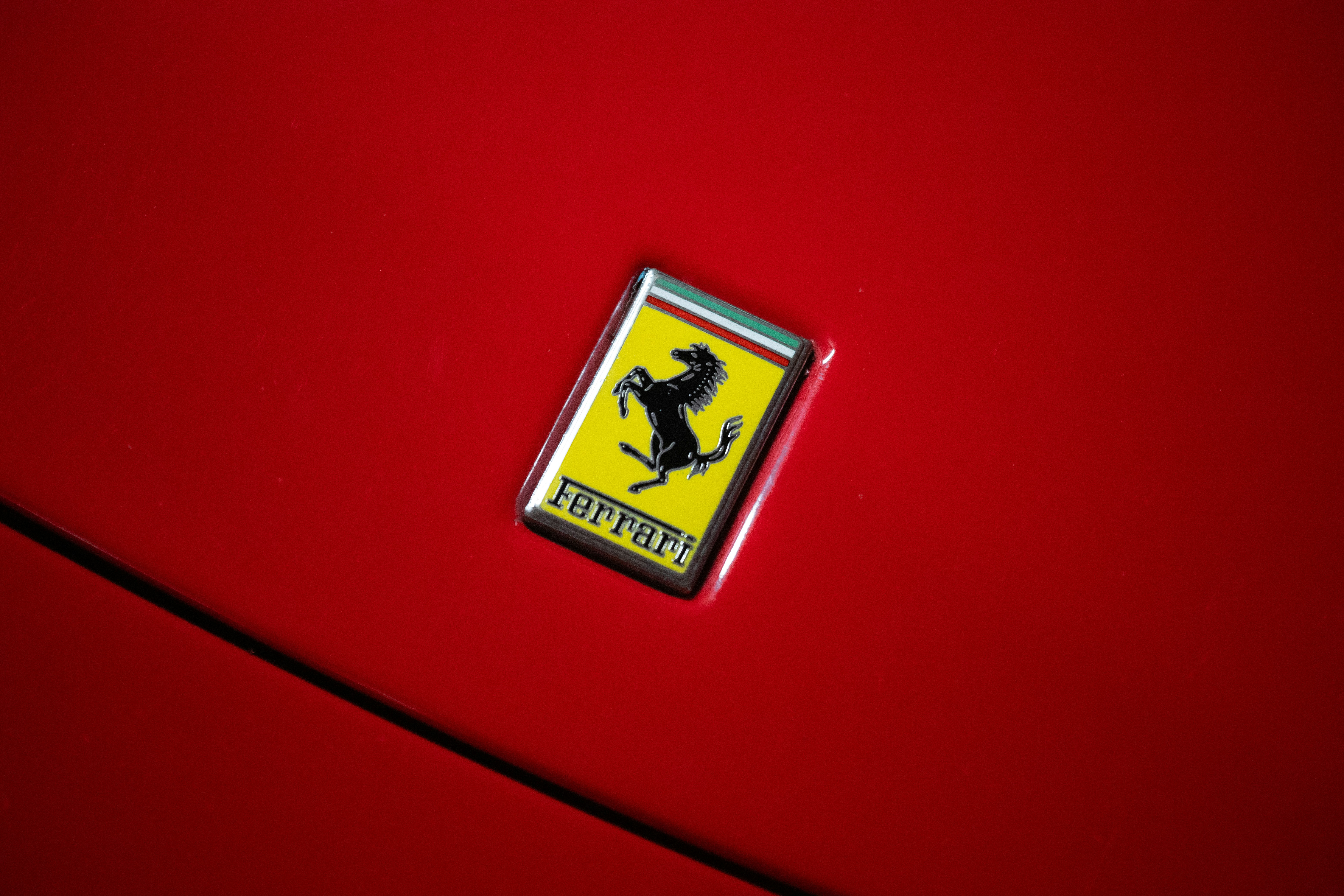 Ferrari Emblem on Red Gloss, A Quiet Focus on Precision