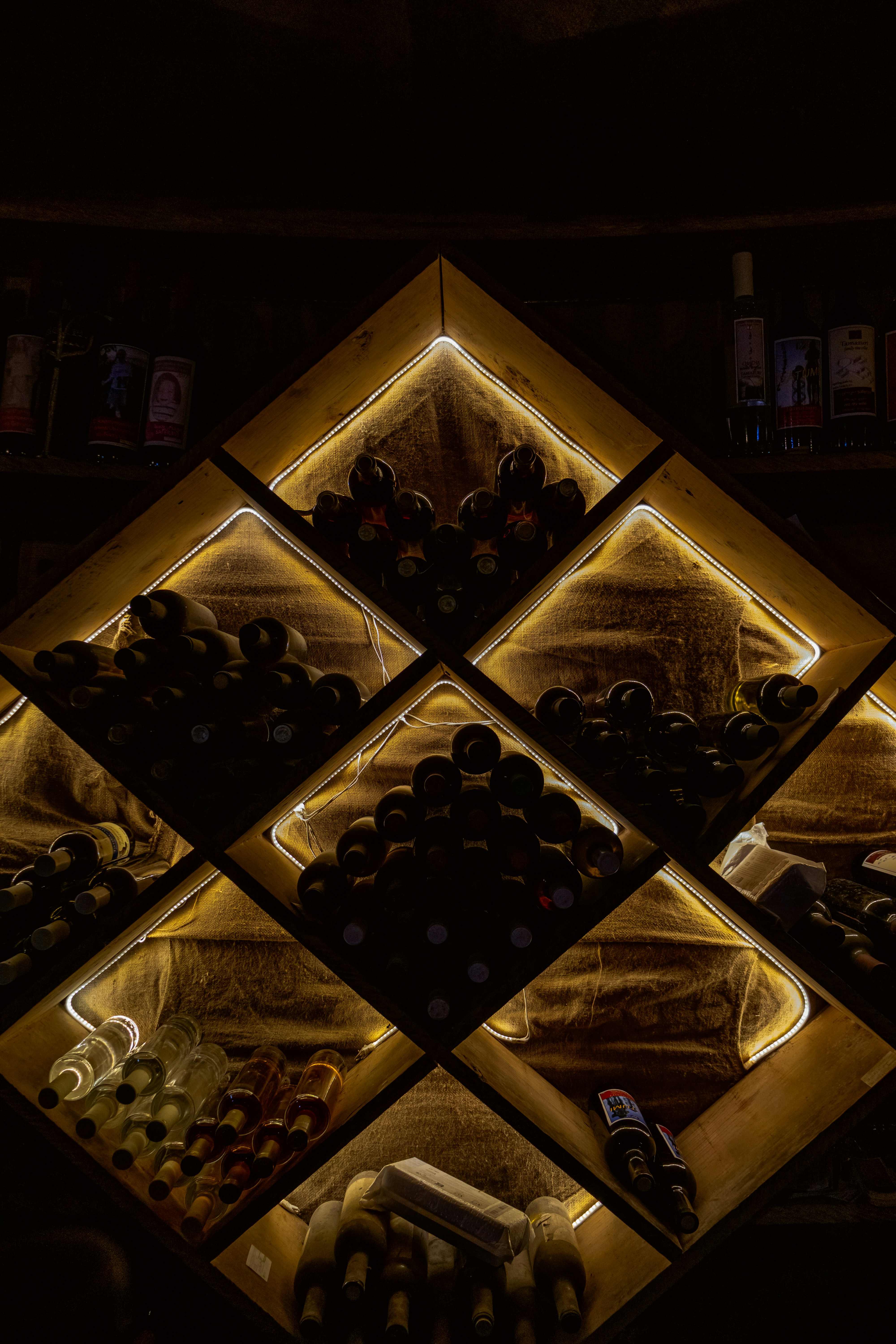 Diamond-Bathed Bottles: A Cozy Wall of Wine Under Warm Neon