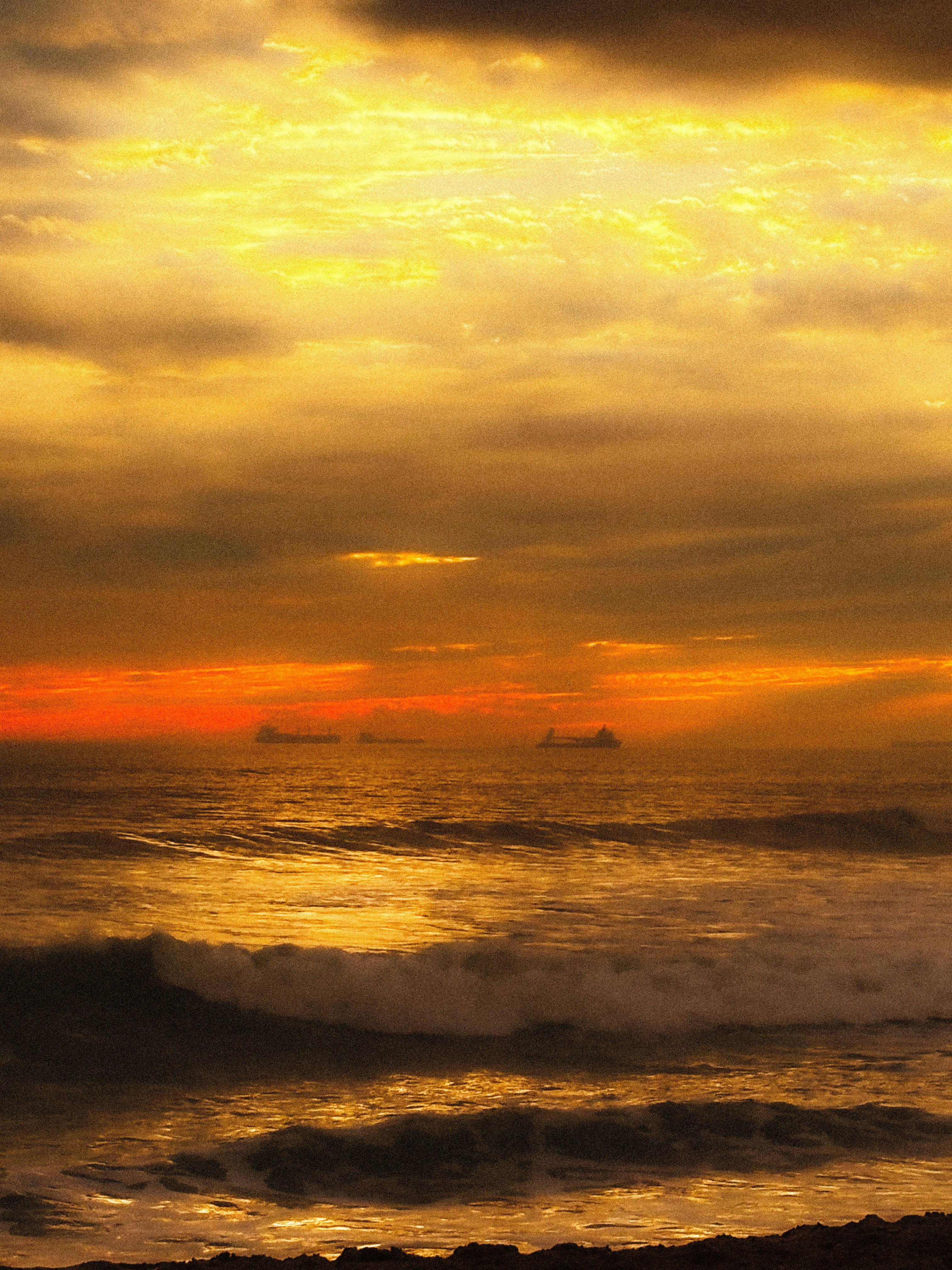 Sunset Over Silent Tides: Distant Ships on a Golden Sea