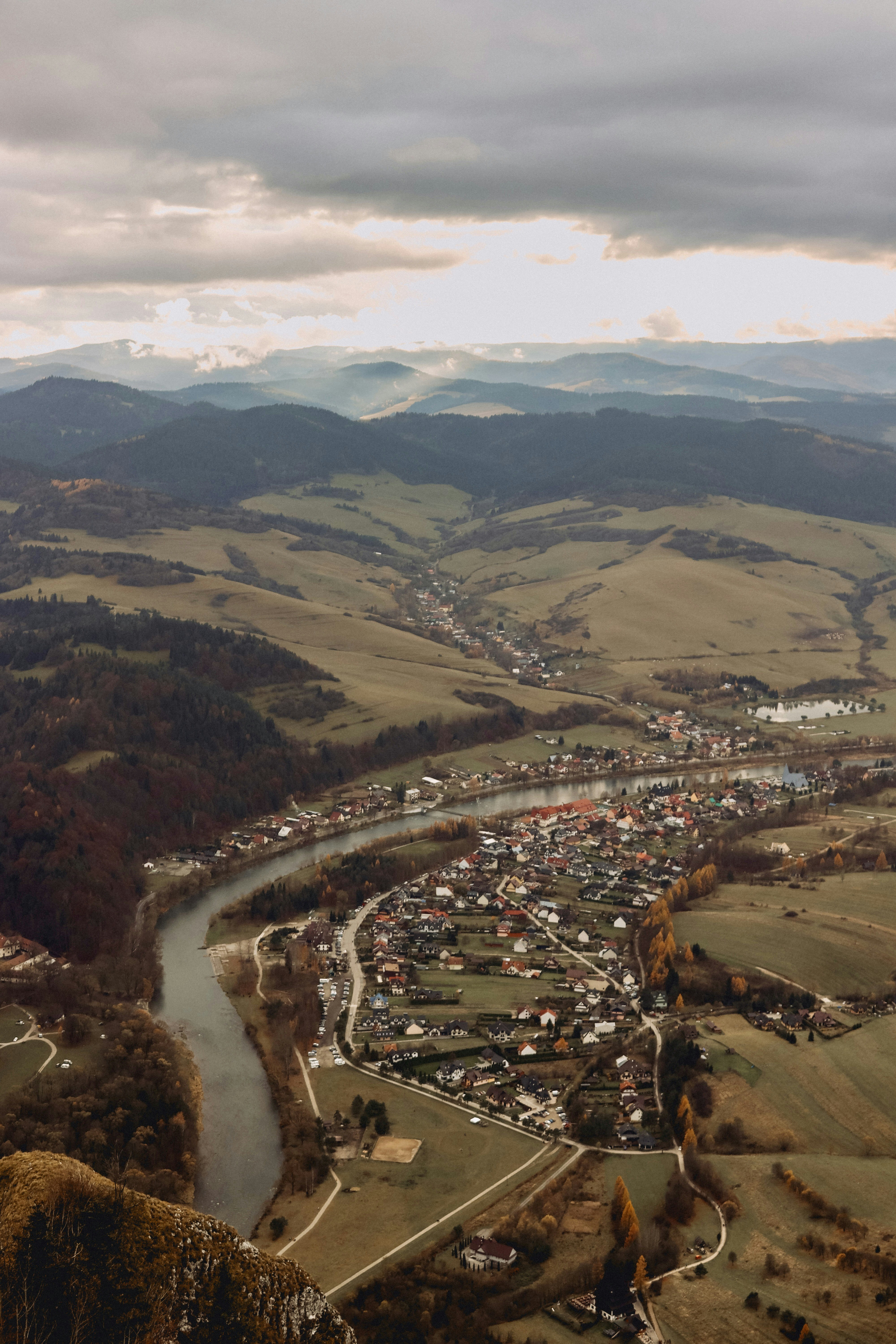 River meanders through a hillside village tucked in a valley