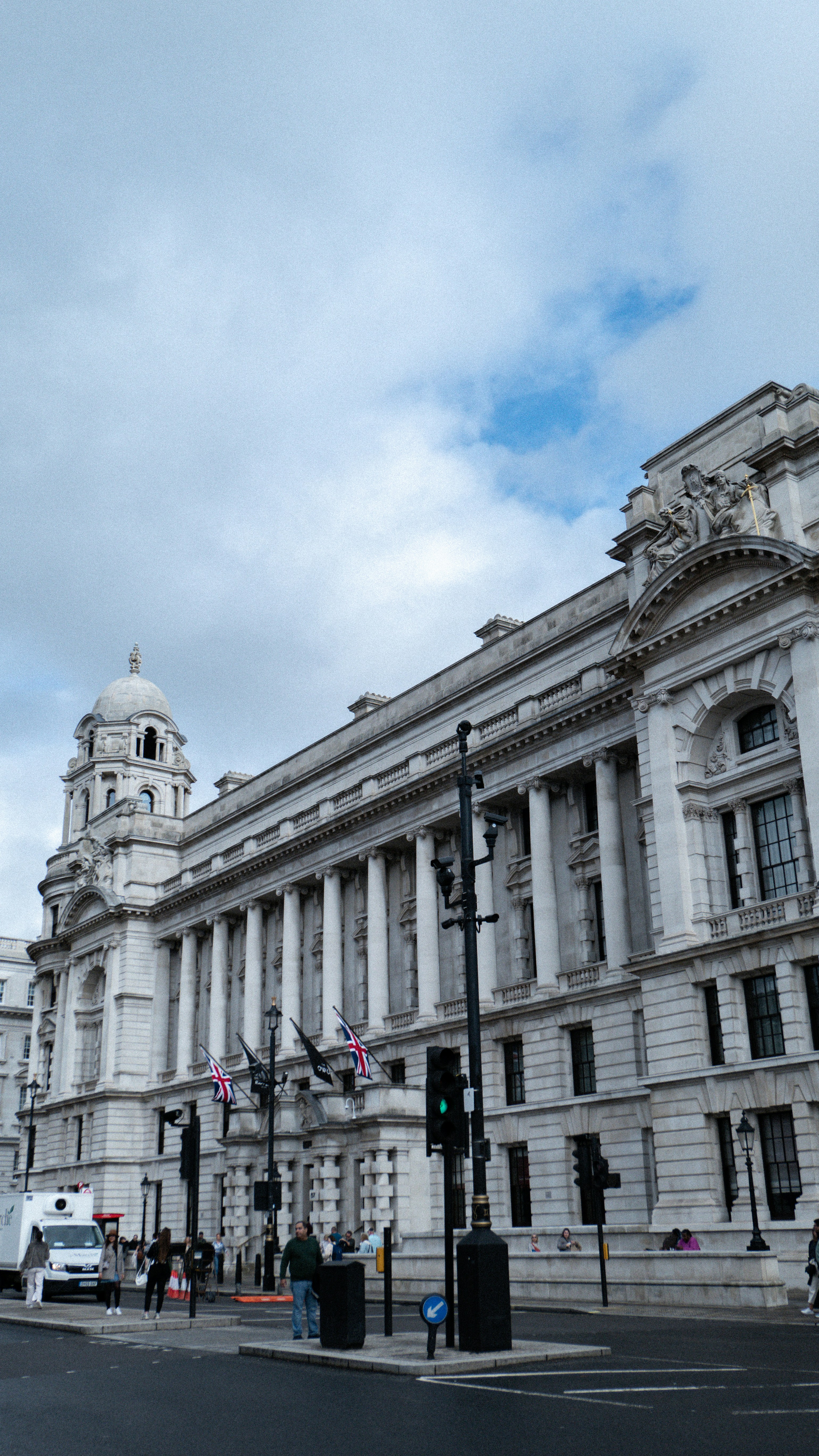 Stone Grandeur: A City Facade Under a Sky of Clouded Blue