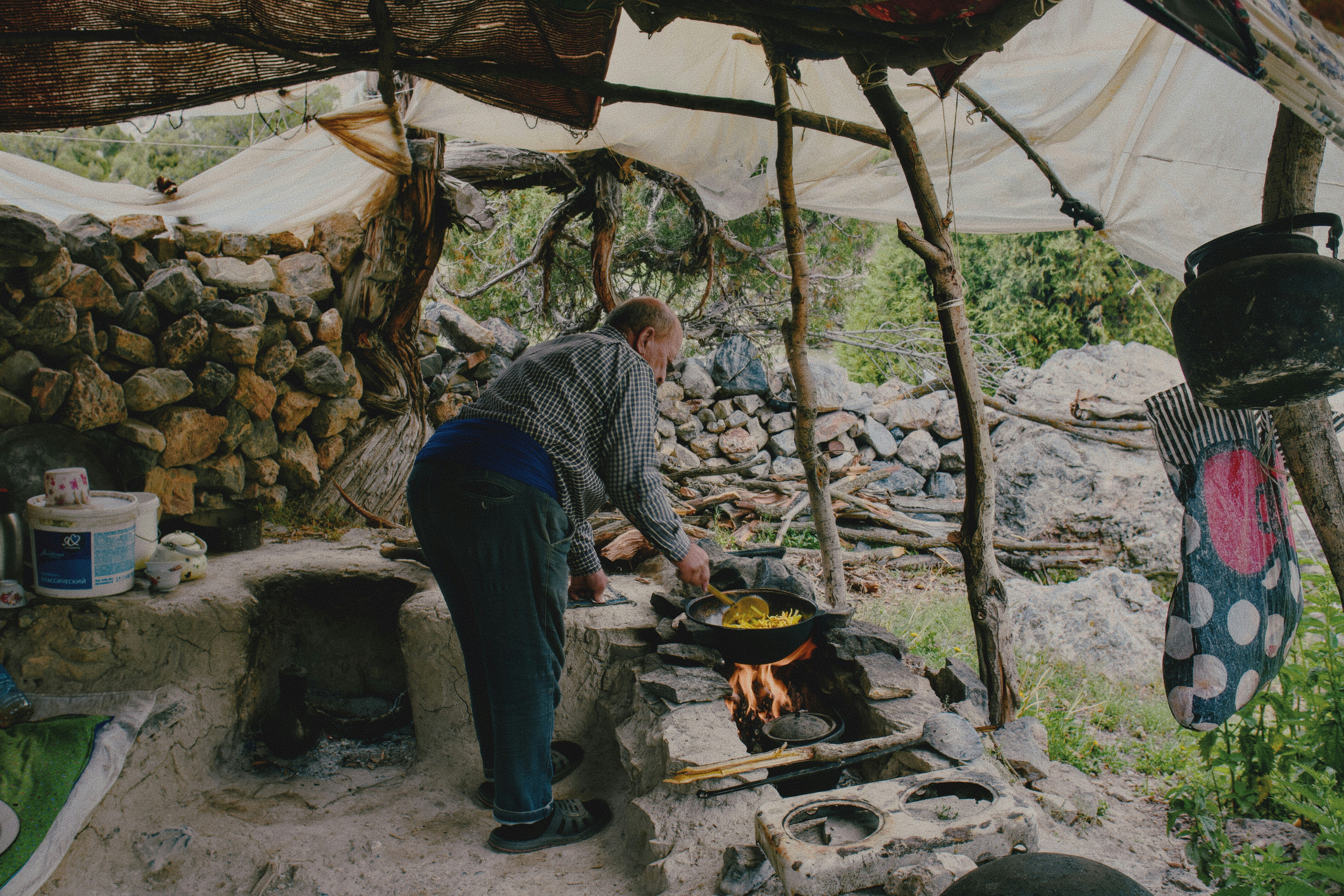Cooking over Coals: A Camper’s Focused Kitchen in a Rustic Shelter