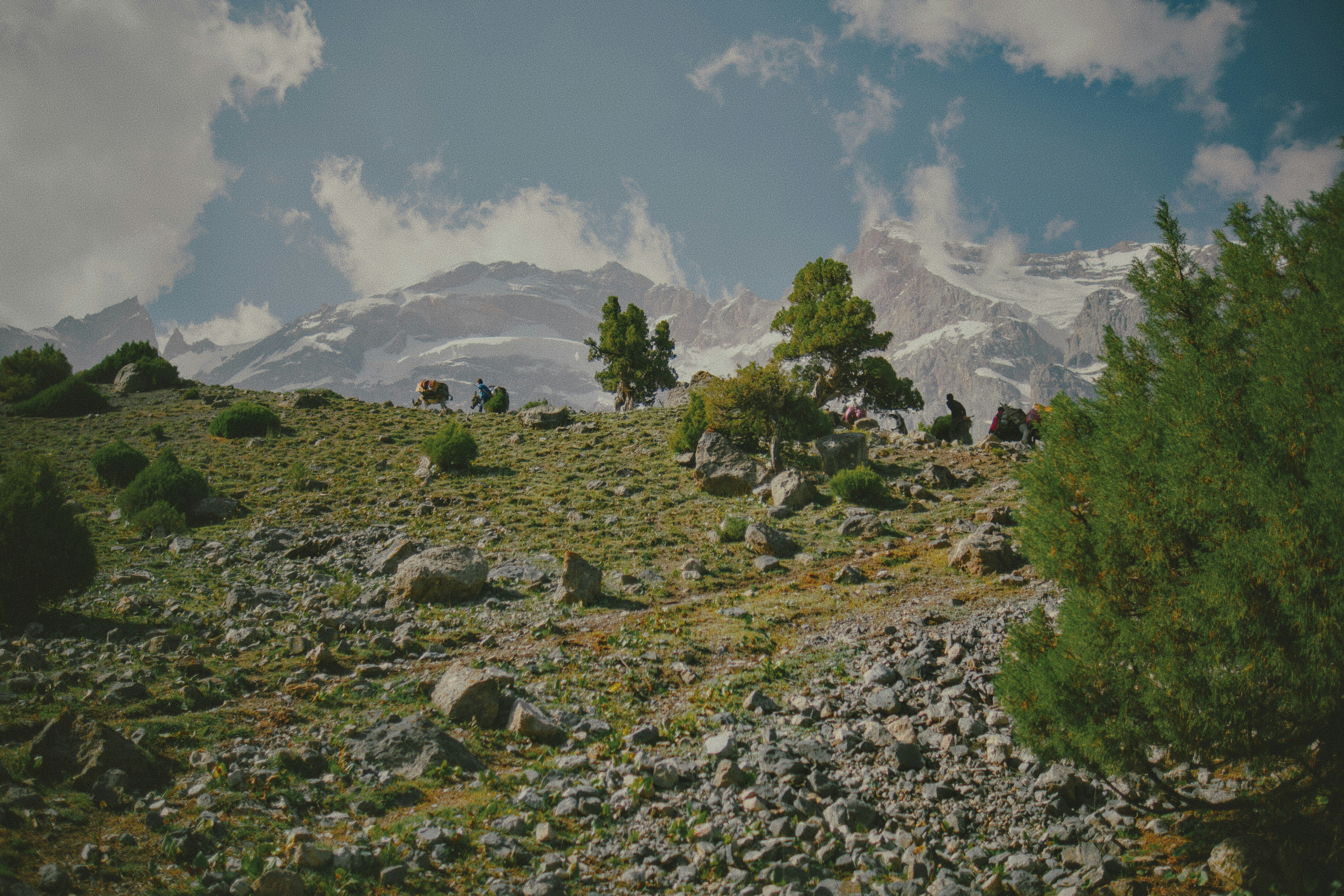 Ridge Top with Climbers Beneath Snowy Peaks