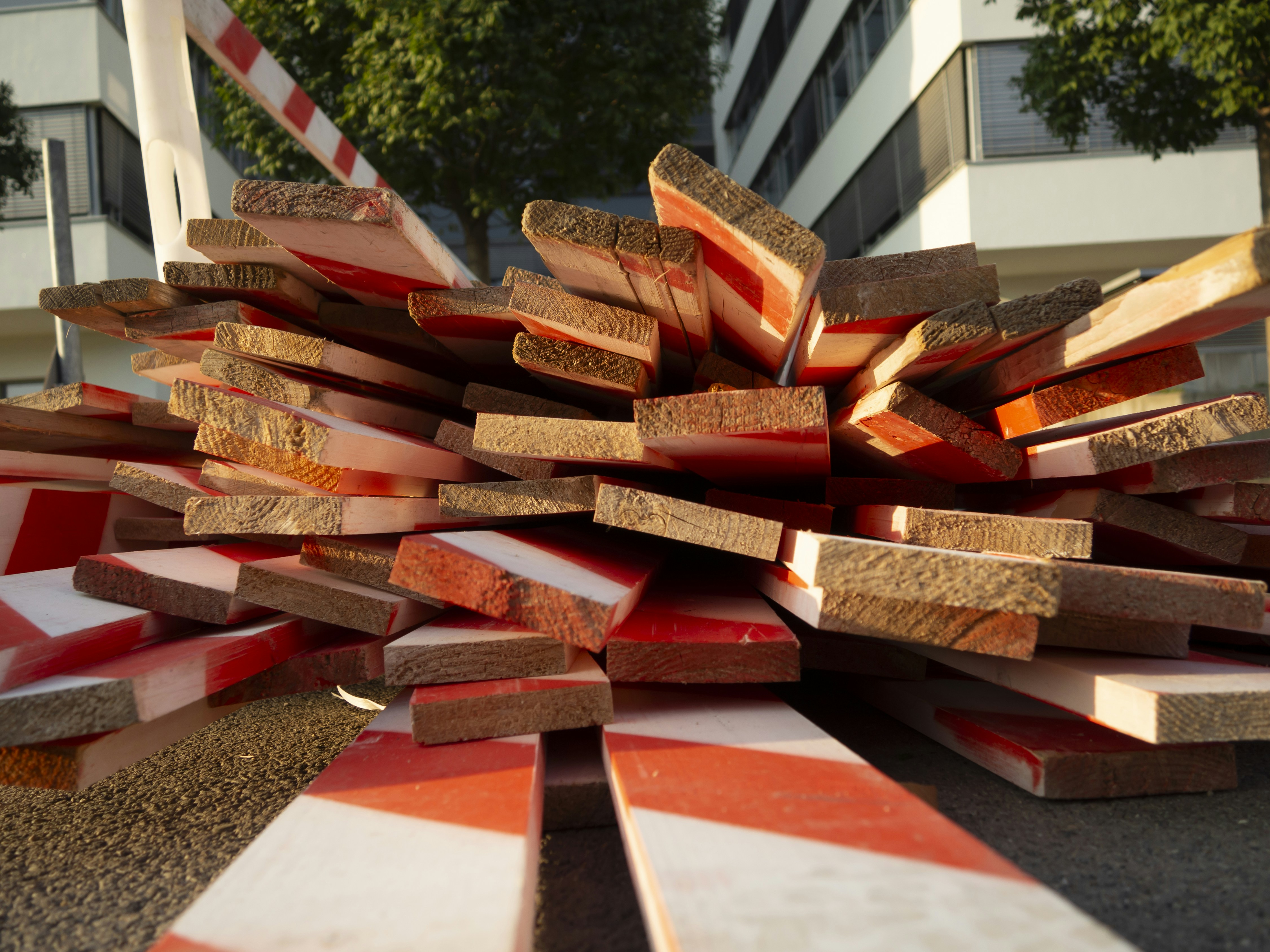 Stacked Slice: Red-White Striped Wood Blocks in Urban Square