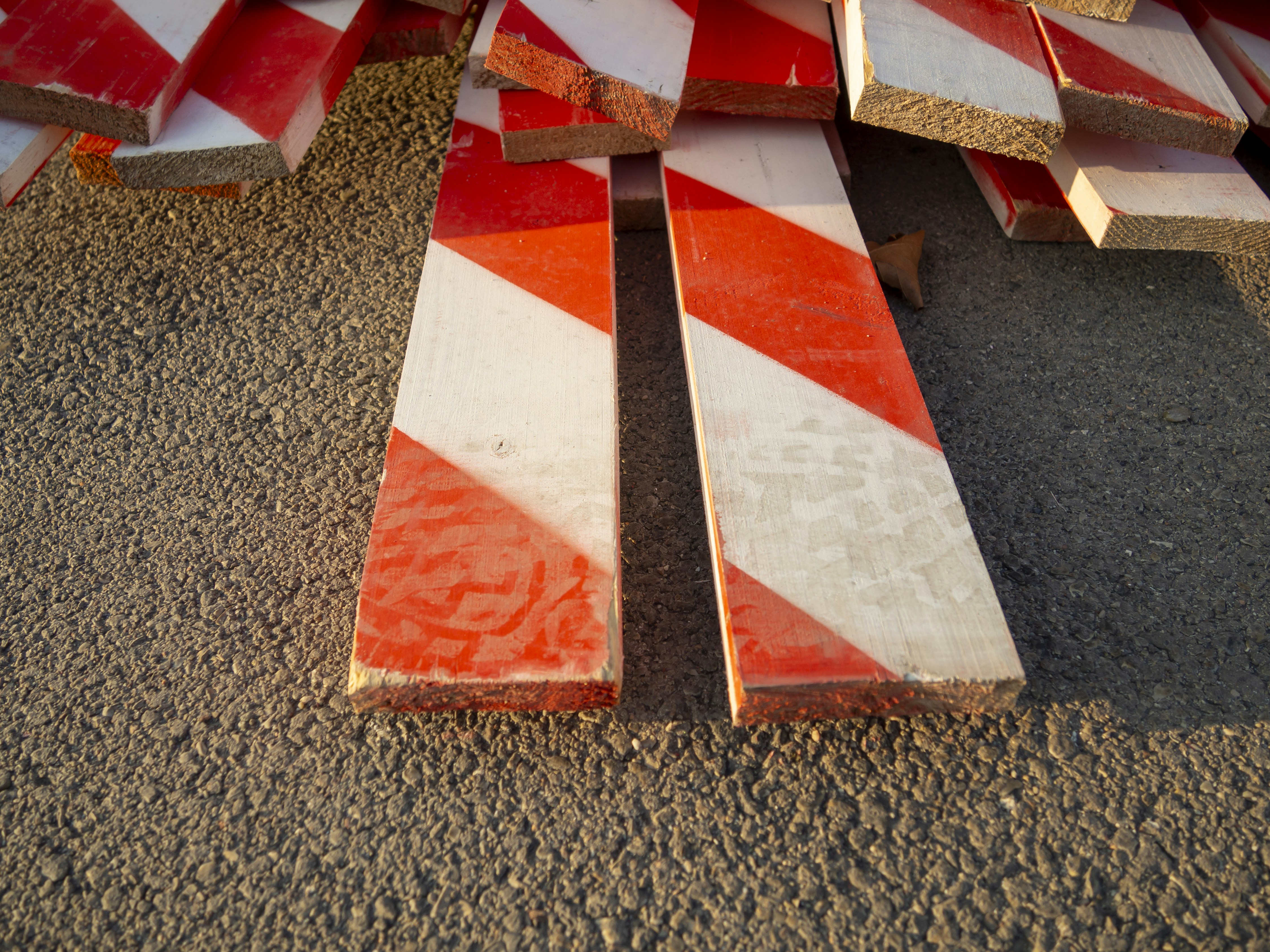 Diagonal Orange-and-White Barriers Resting on Rough Gravel