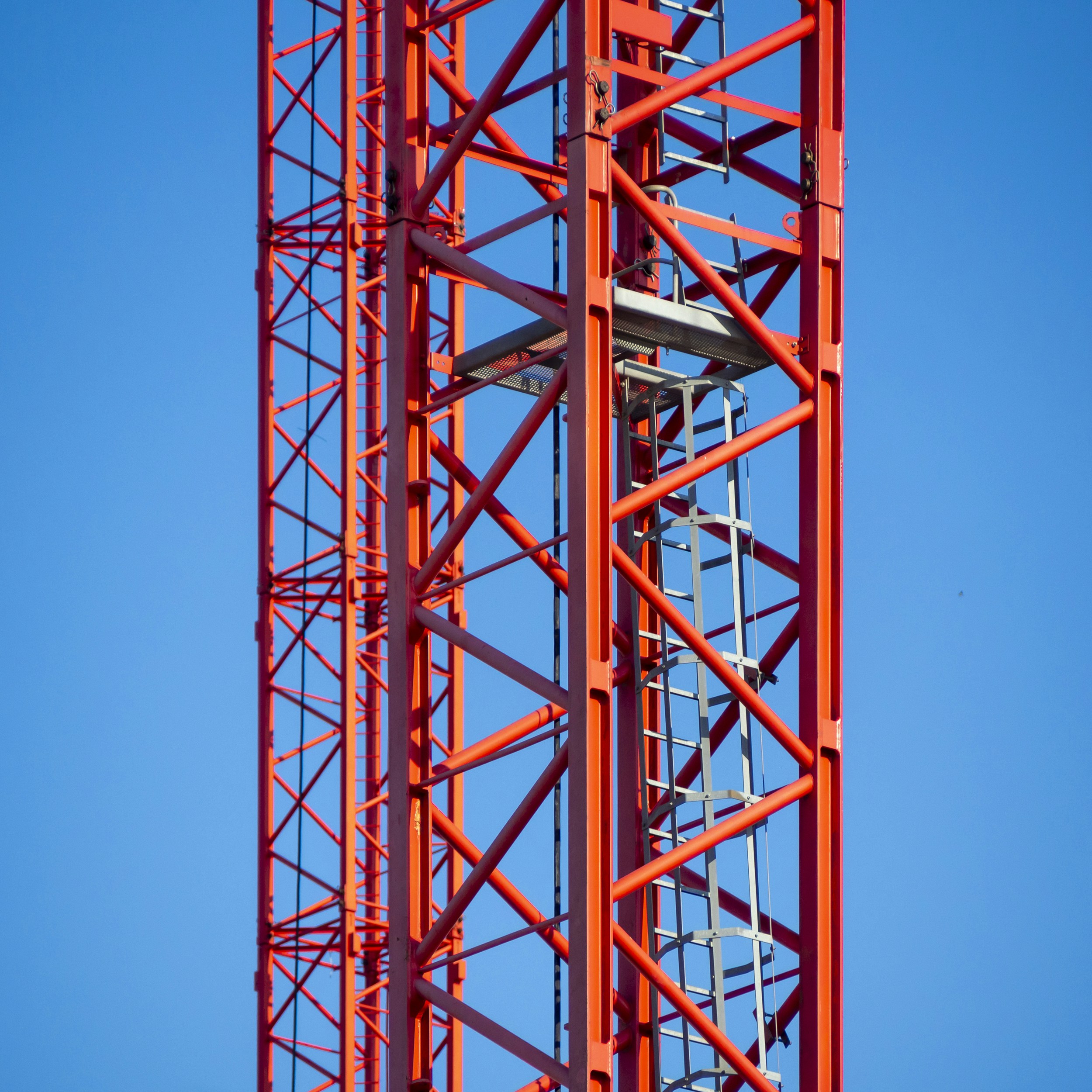 Crimson Crane: A Lean Red Tower Piercing the Sky