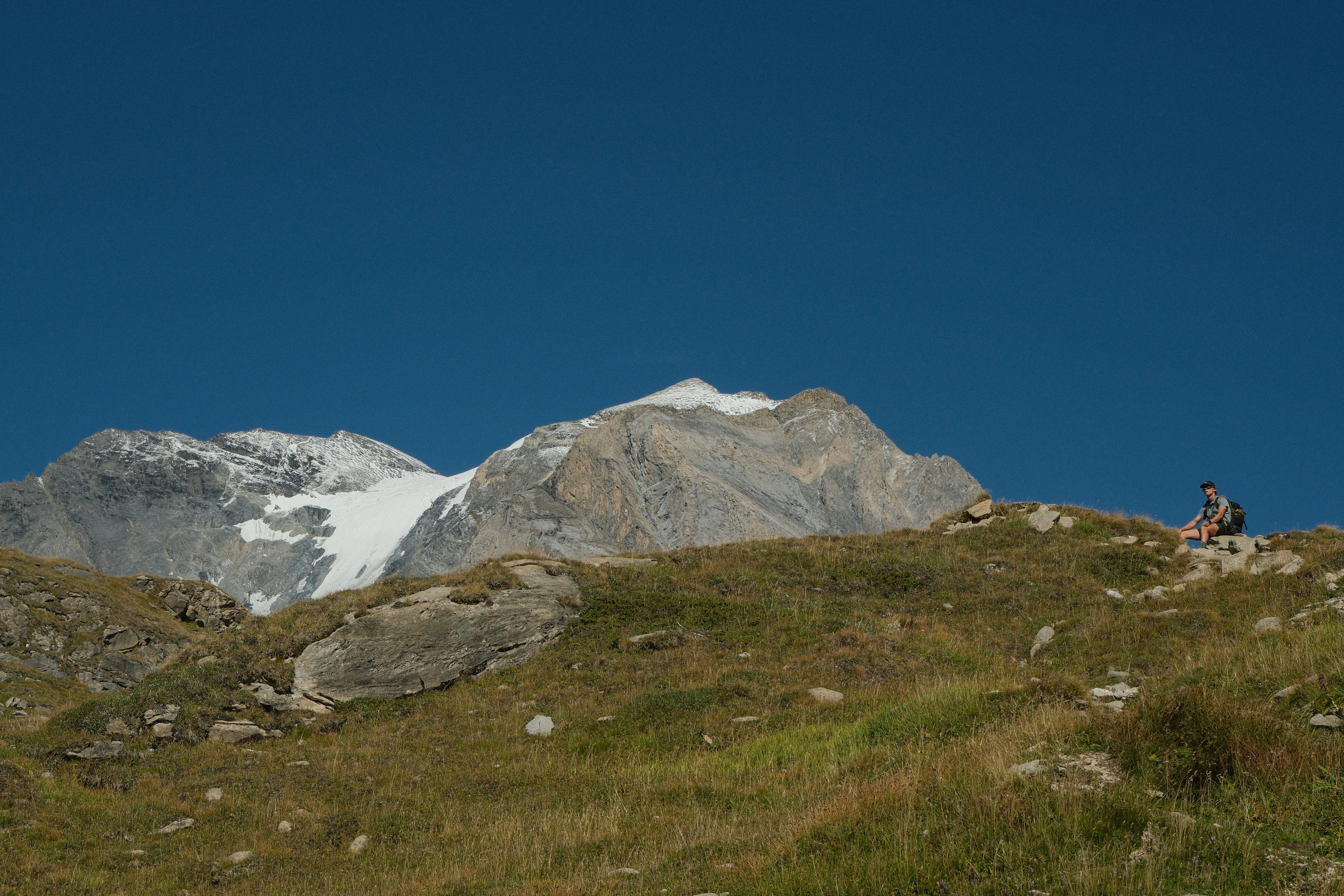 Hiker in the Tundra Summit: A Sliver of Silence Beneath Snow-Capped Peaks
