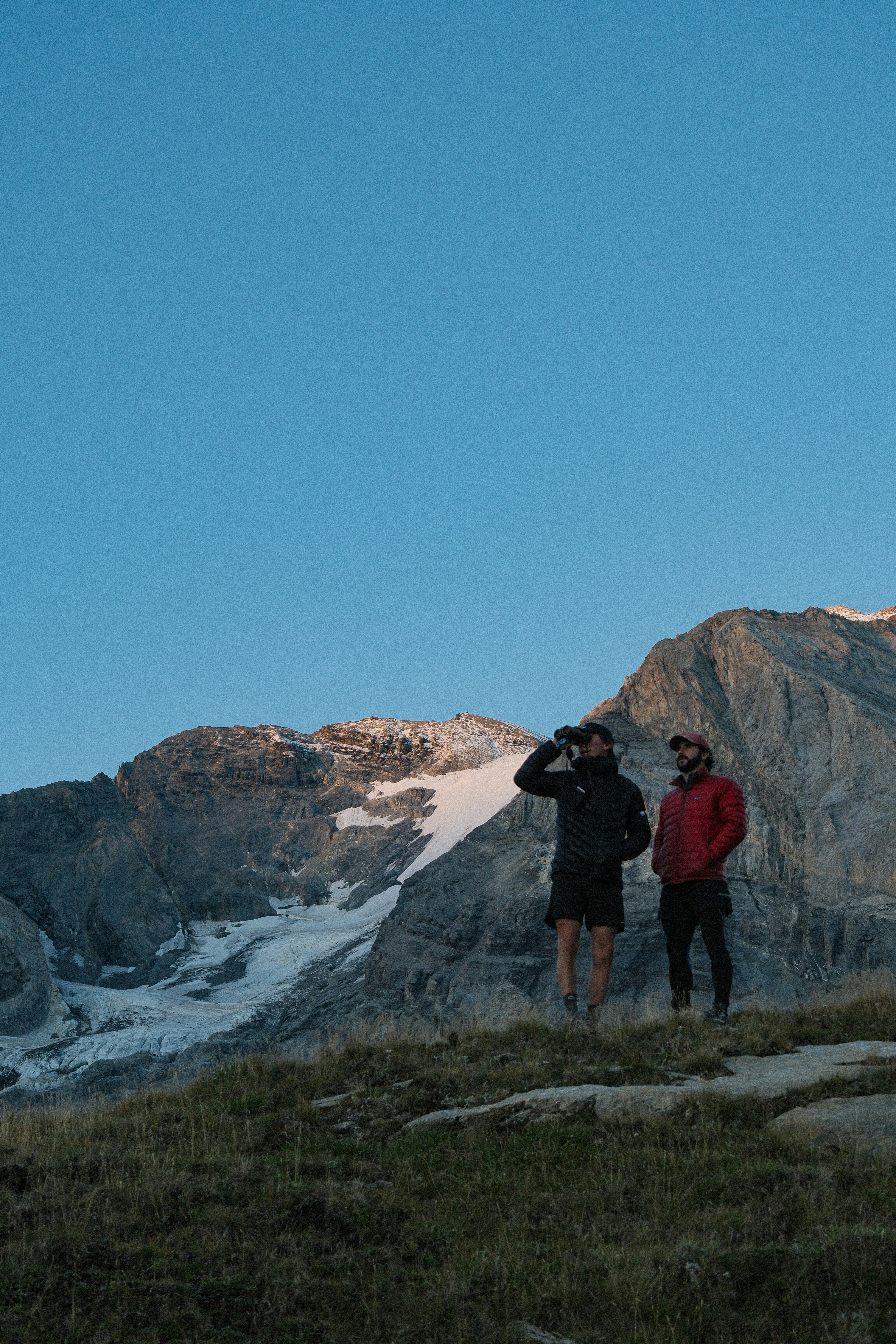 Glacial Lookout: Two Explorers Scout the Ridge at Twilight