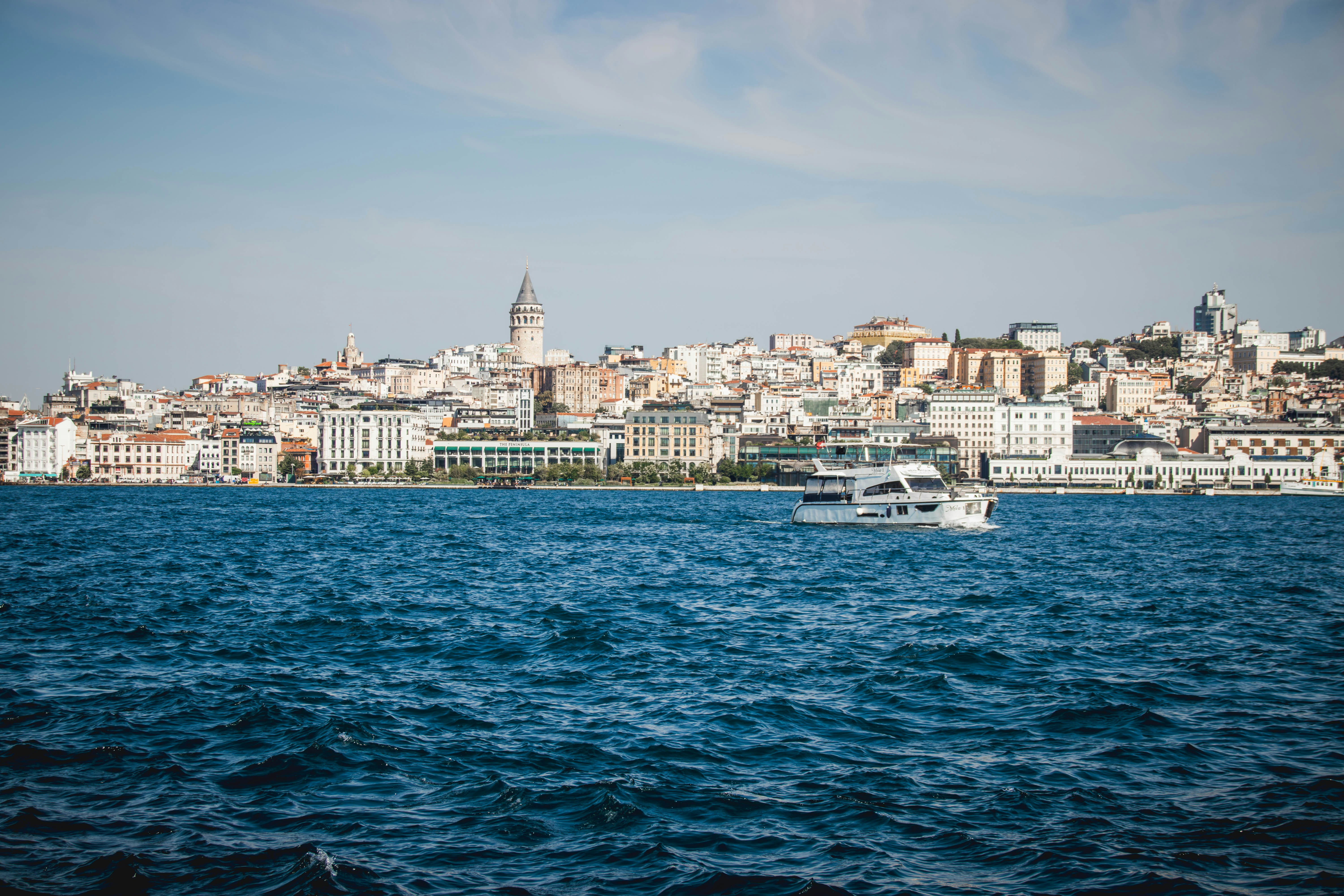 City on the Edge: A Coastal Panorama with a Vessel Crossing the Blue Horizon