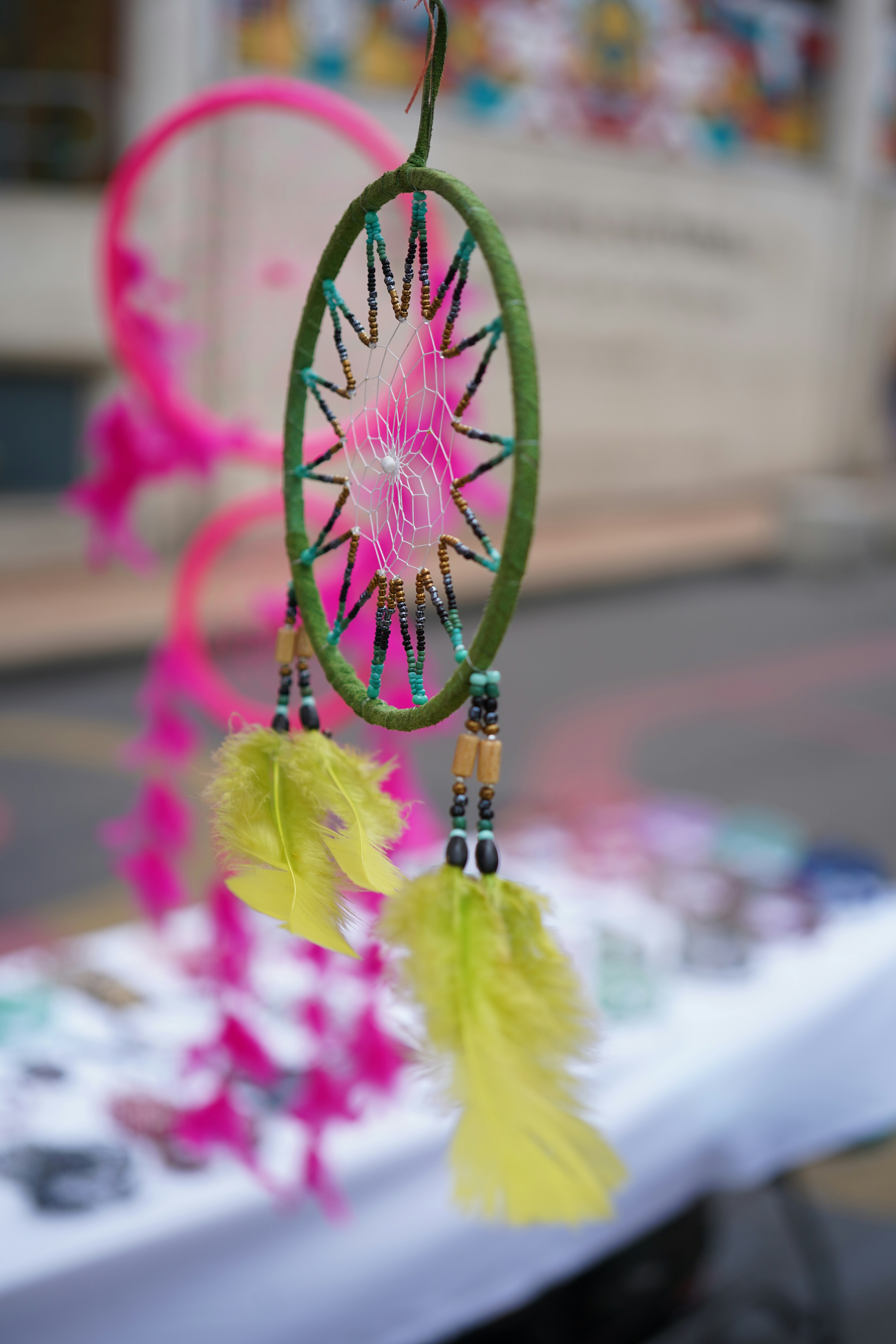 Dreamcatcher in Focus: Colorful Orbs with Feathers at Street Market