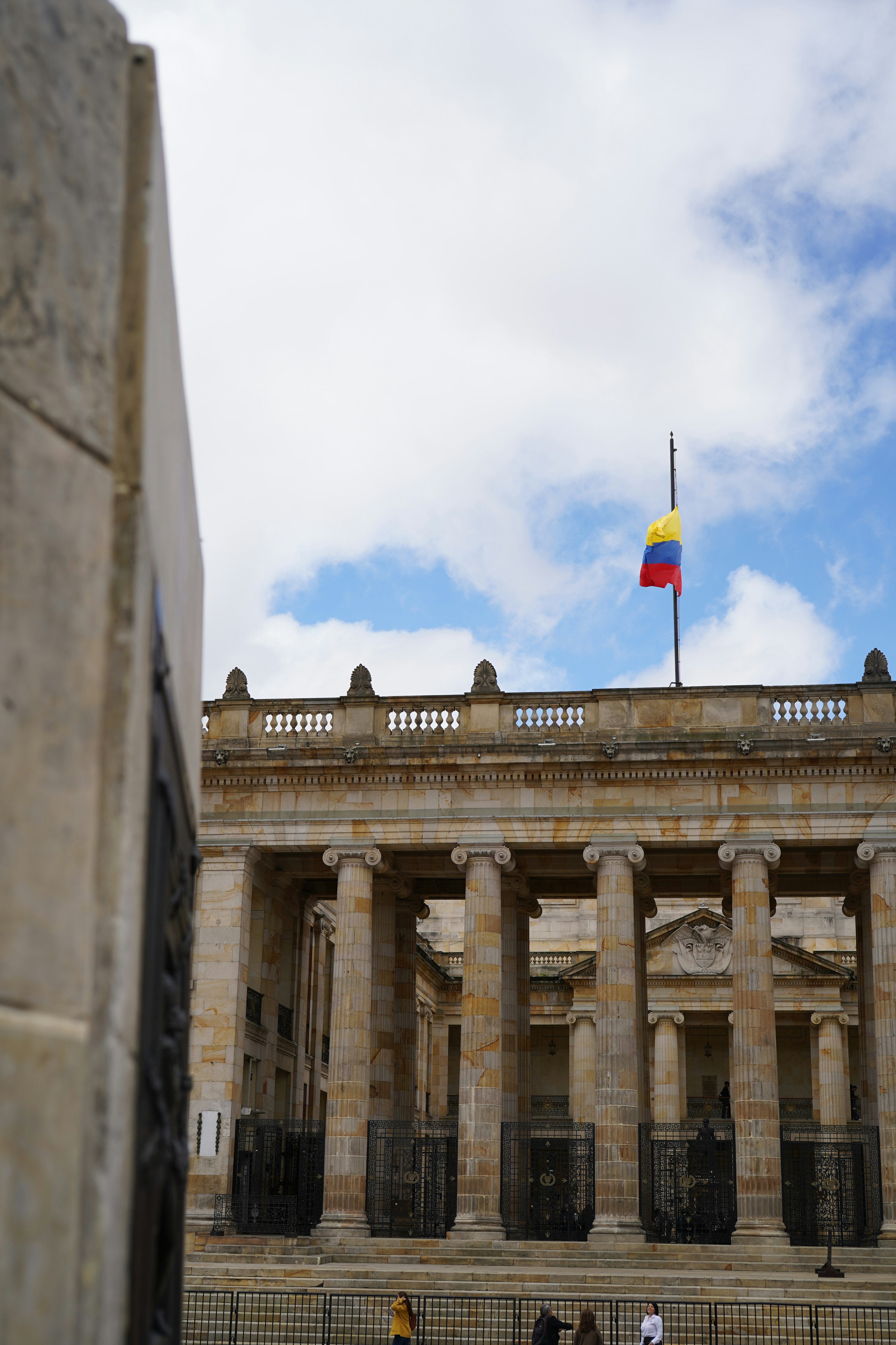 Colonnade and Flag: A Colombian Blue Sky Over a Historic Facade