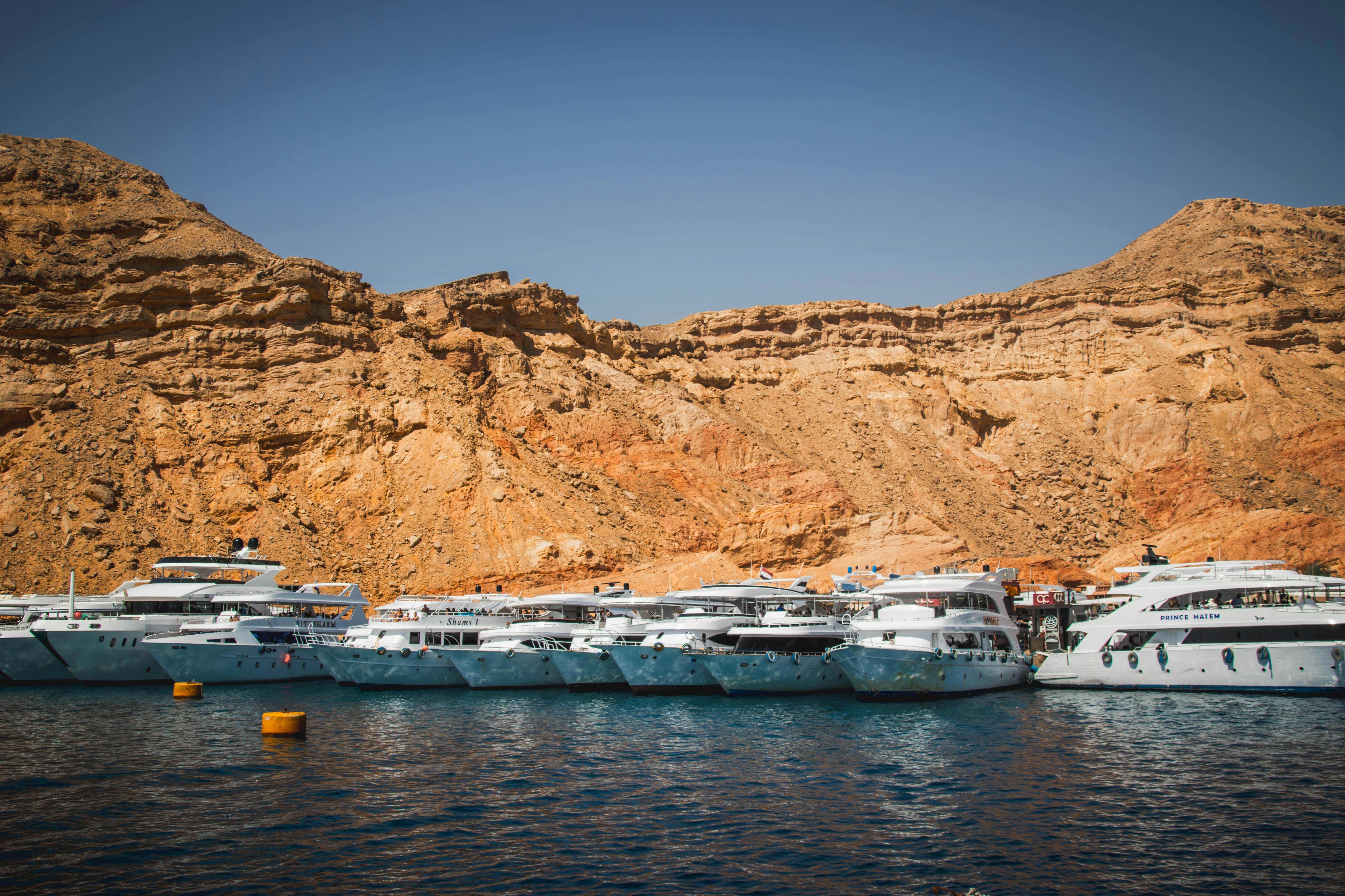 Harbor of Luxurious Quiet: Yachts Lined Against Arid Cliffs