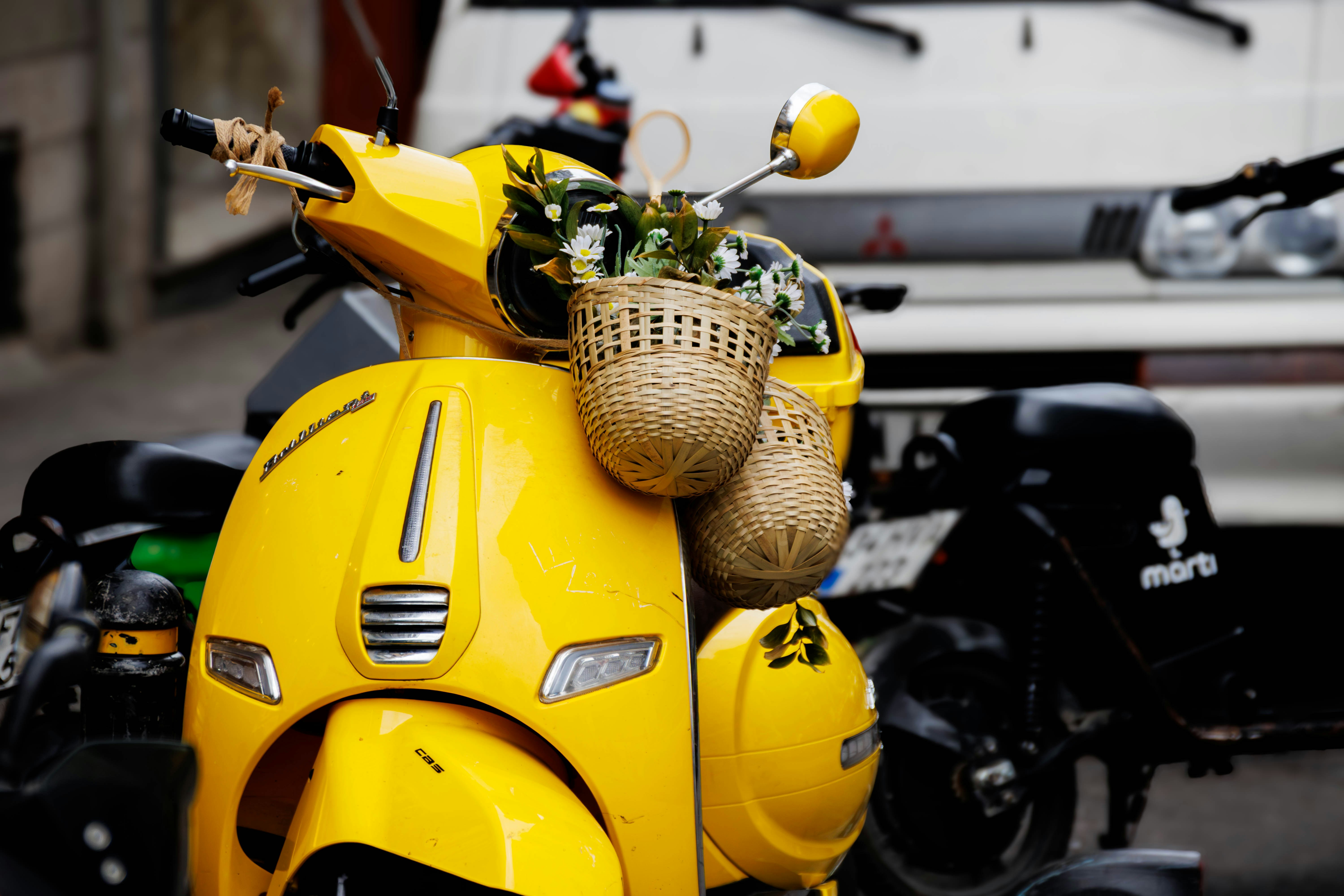 Yellow Vespa with Floral Basket Crest: A Street-Style Welcome