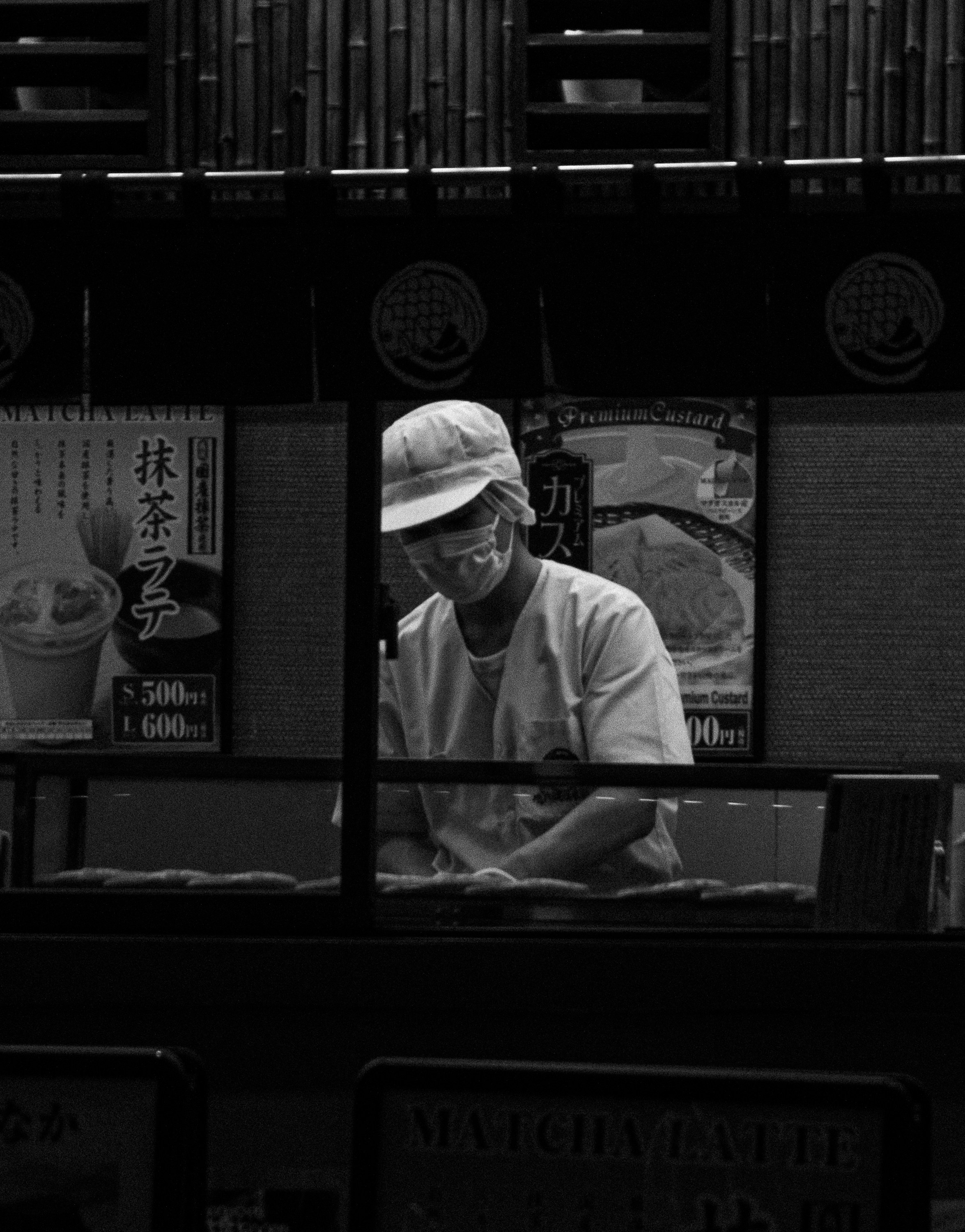 Silhouette of a Food Vendor: Quiet Focus Behind a Menu Window