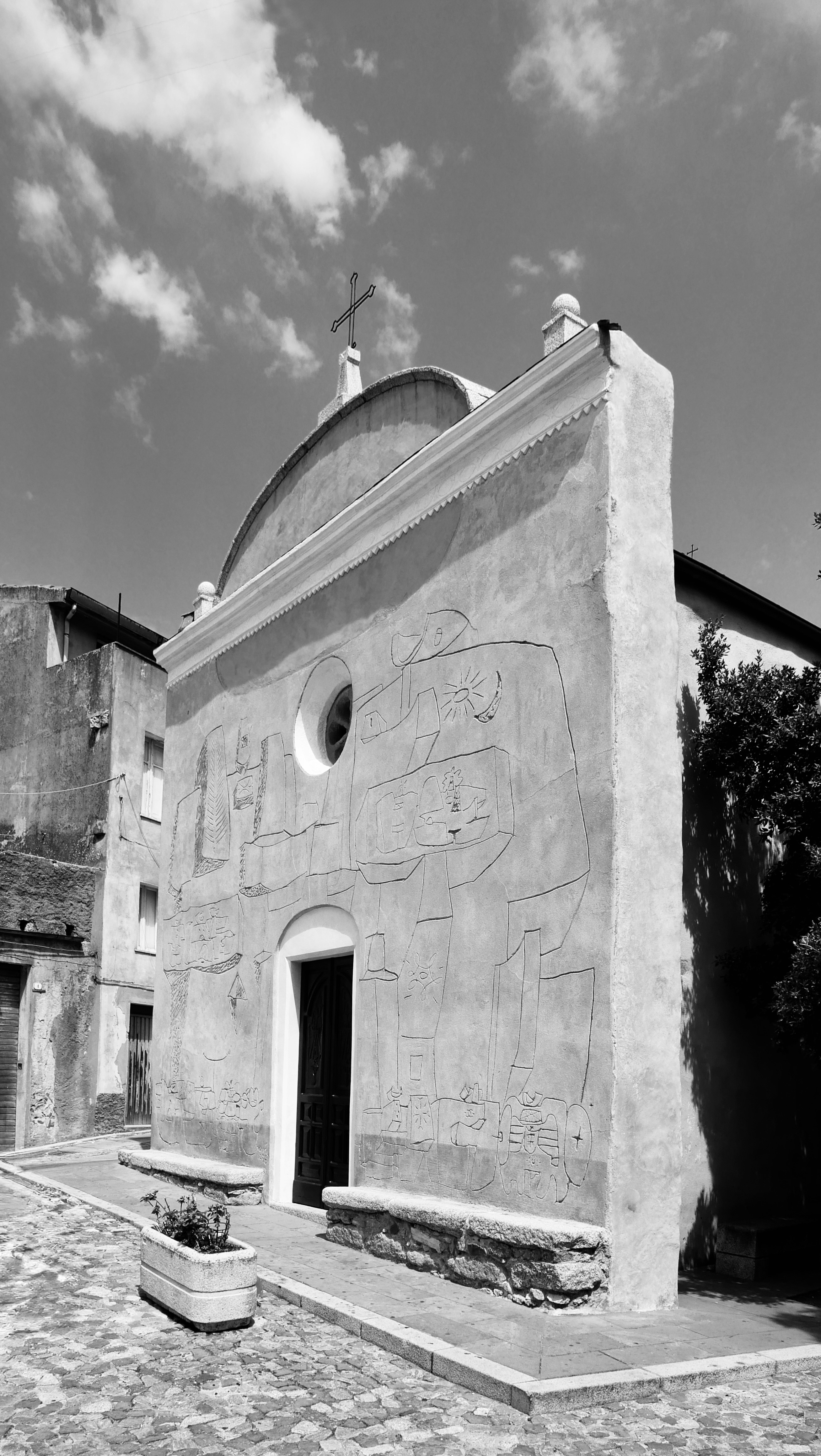 Sunlit Facade with Abstract Wall Carvings in a Narrow Piazzetta