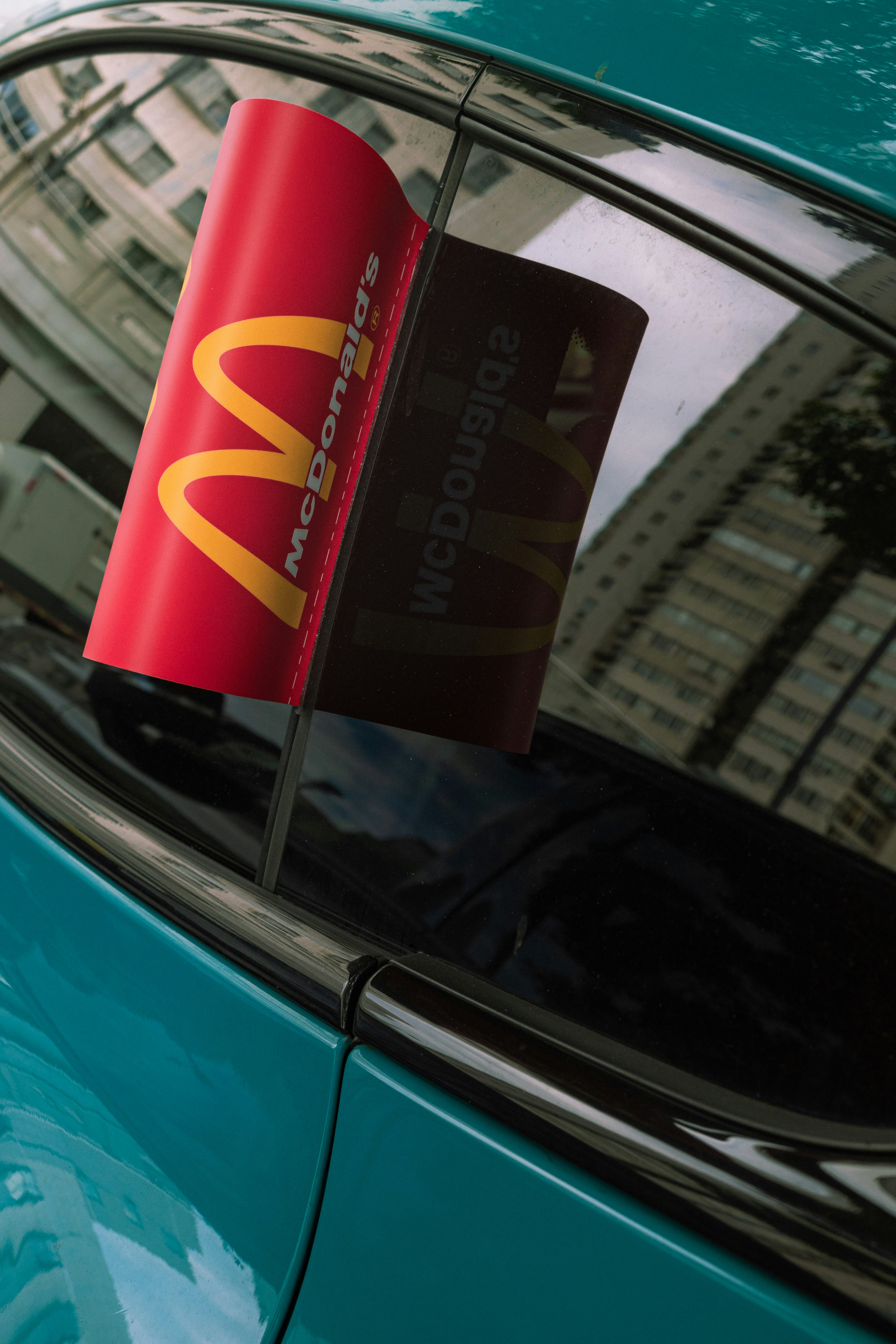 McDonald's reflection: neon arc on teal car window