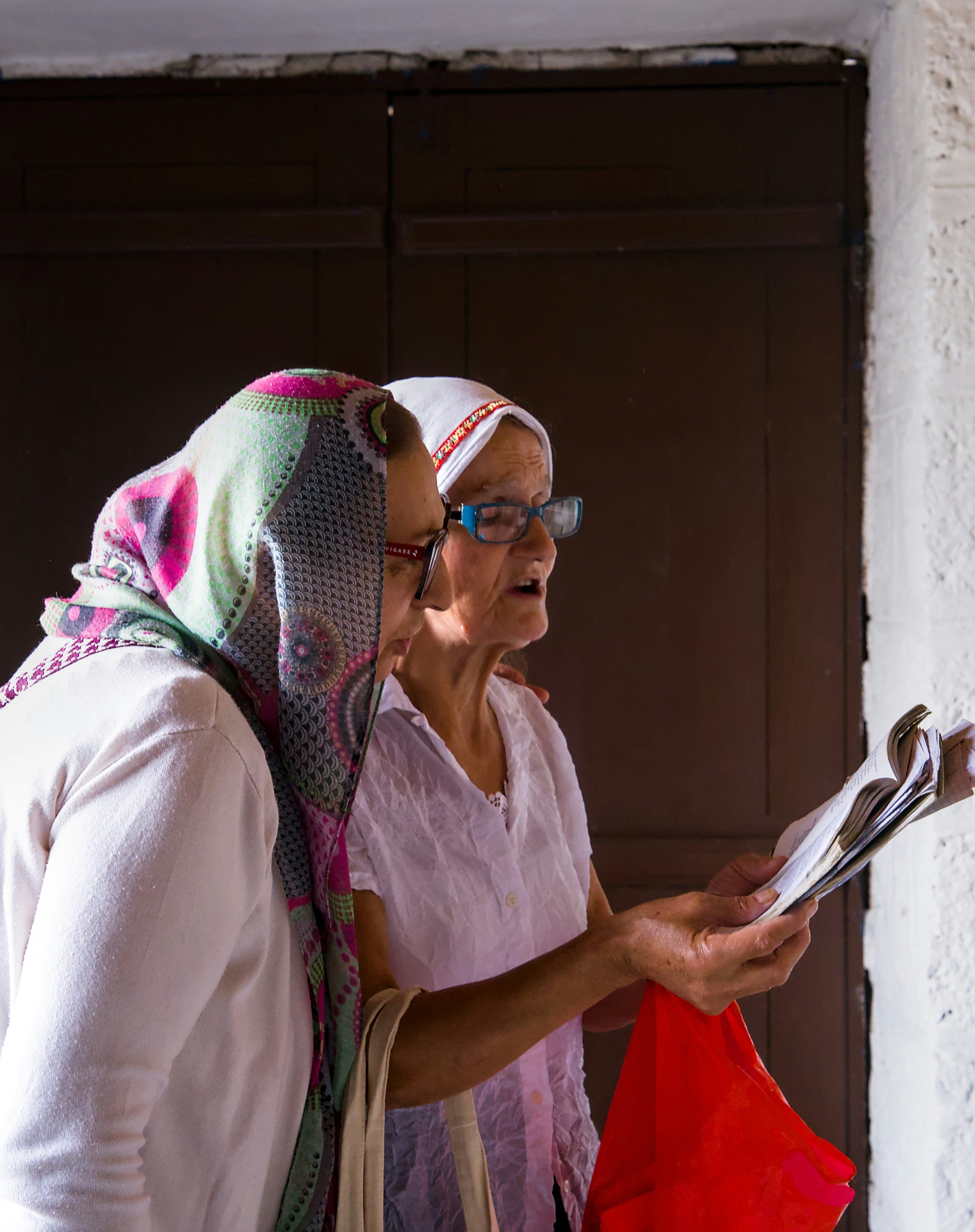Whispered Gallery: Two women in conversation beside a doorway