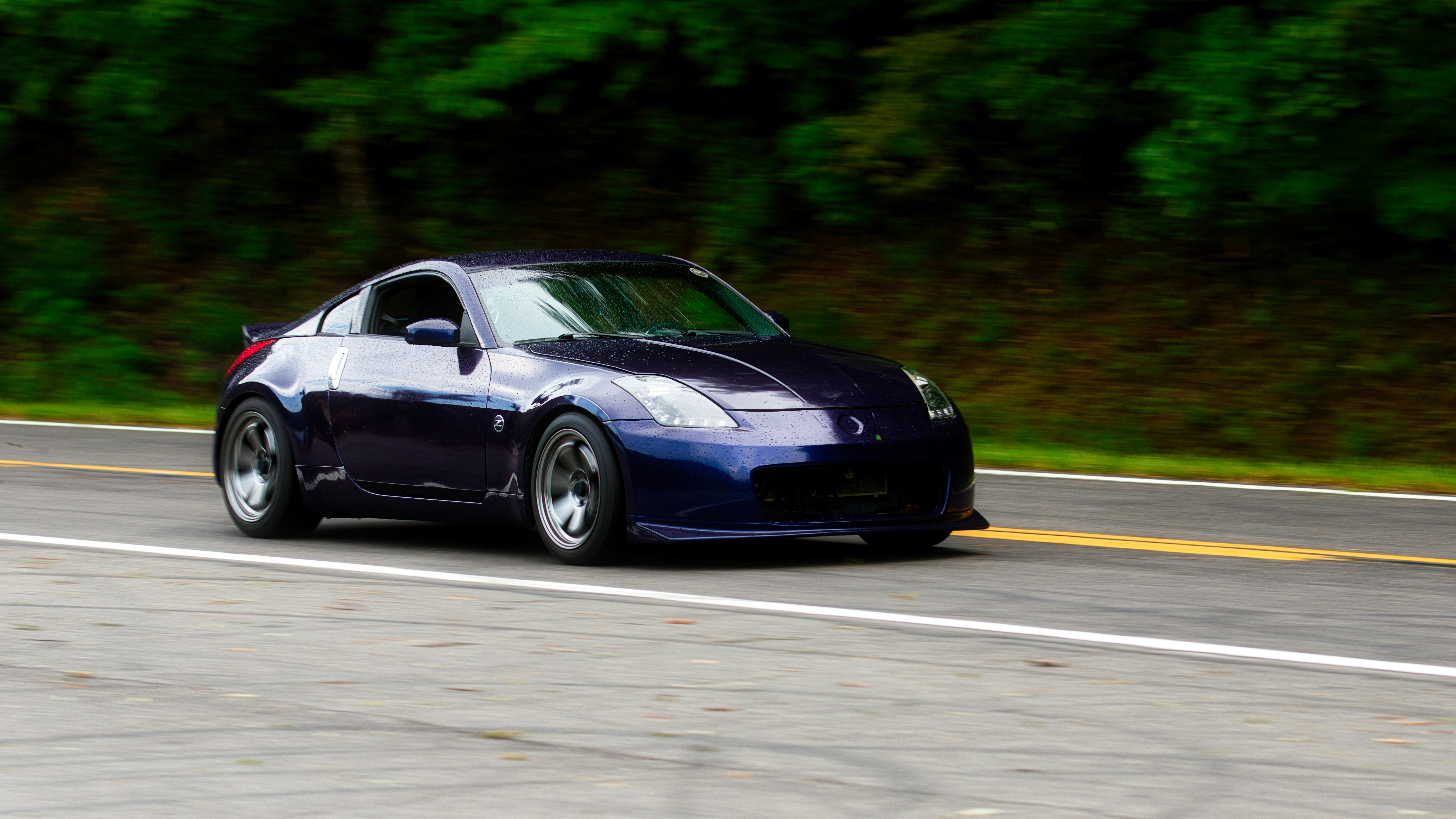 Blue Shadows: A Porsche-like silhouette cruises a sunlit rural road