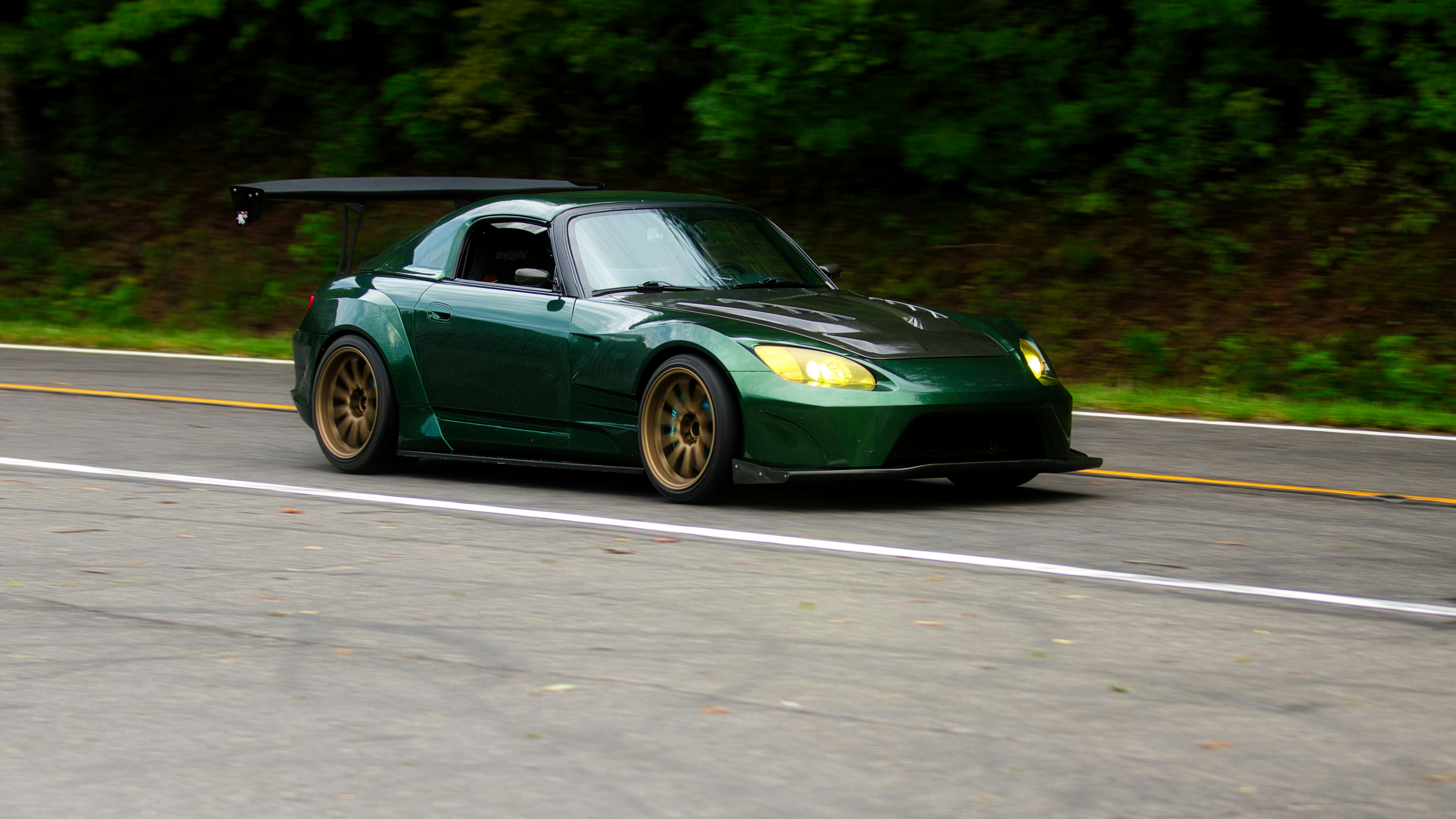 Green drift: a tuned road-tamed coupe slices through a two-lane ribbon