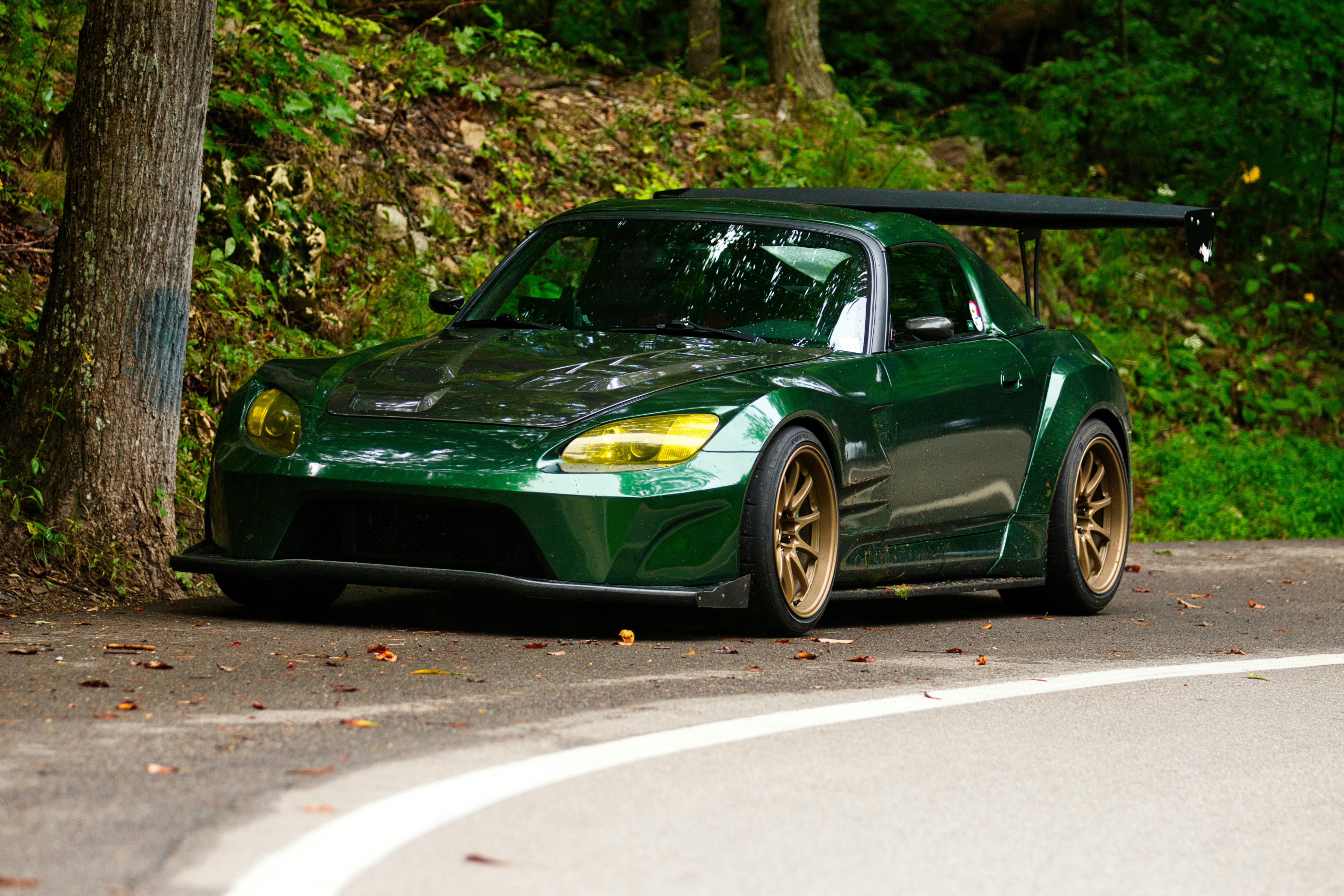 Emerald Racer: A Green Coupé with Giant Wing on a Quiet Road