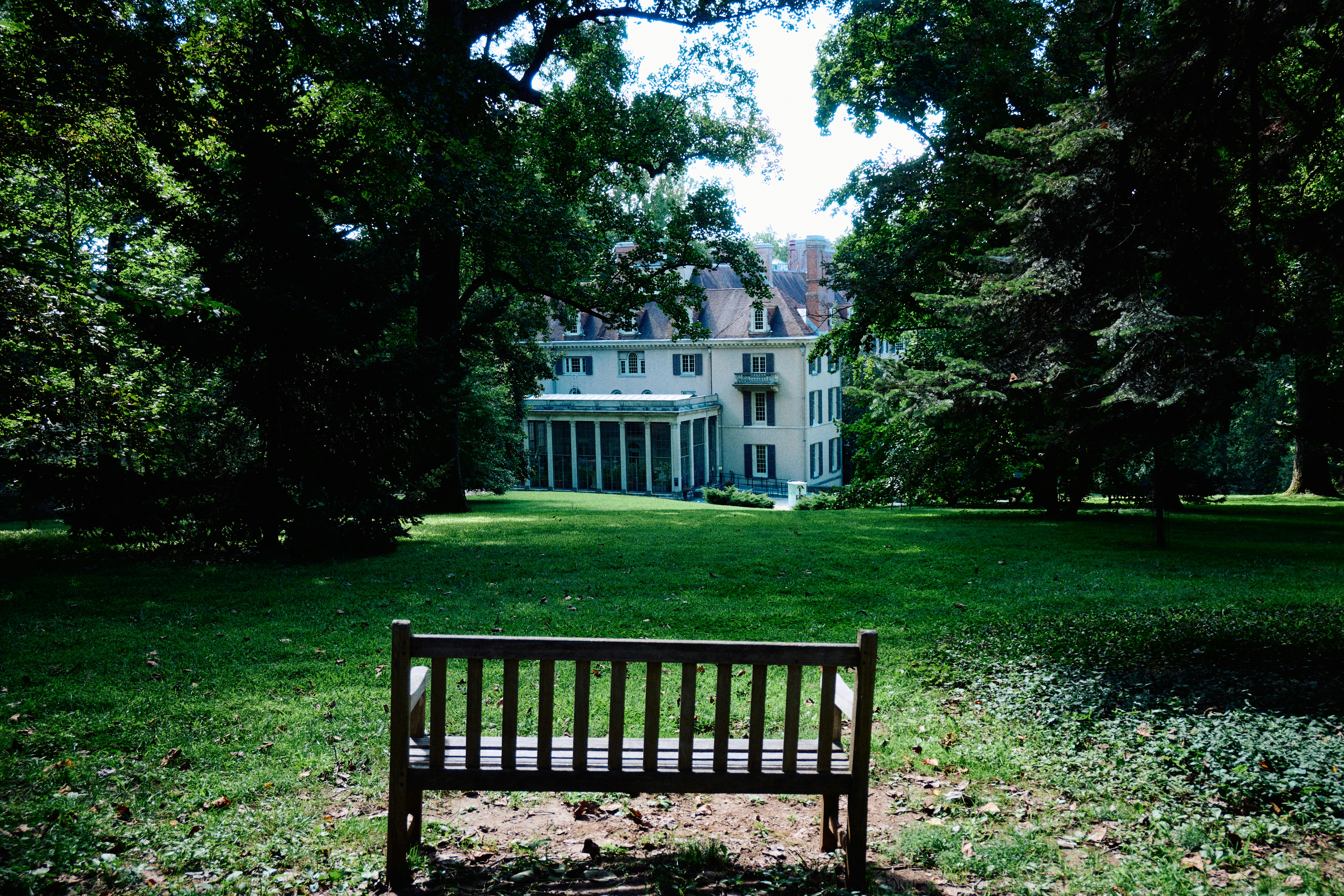 Empty Bench, Grand Estate: A Sunlit Pause Before Arrival