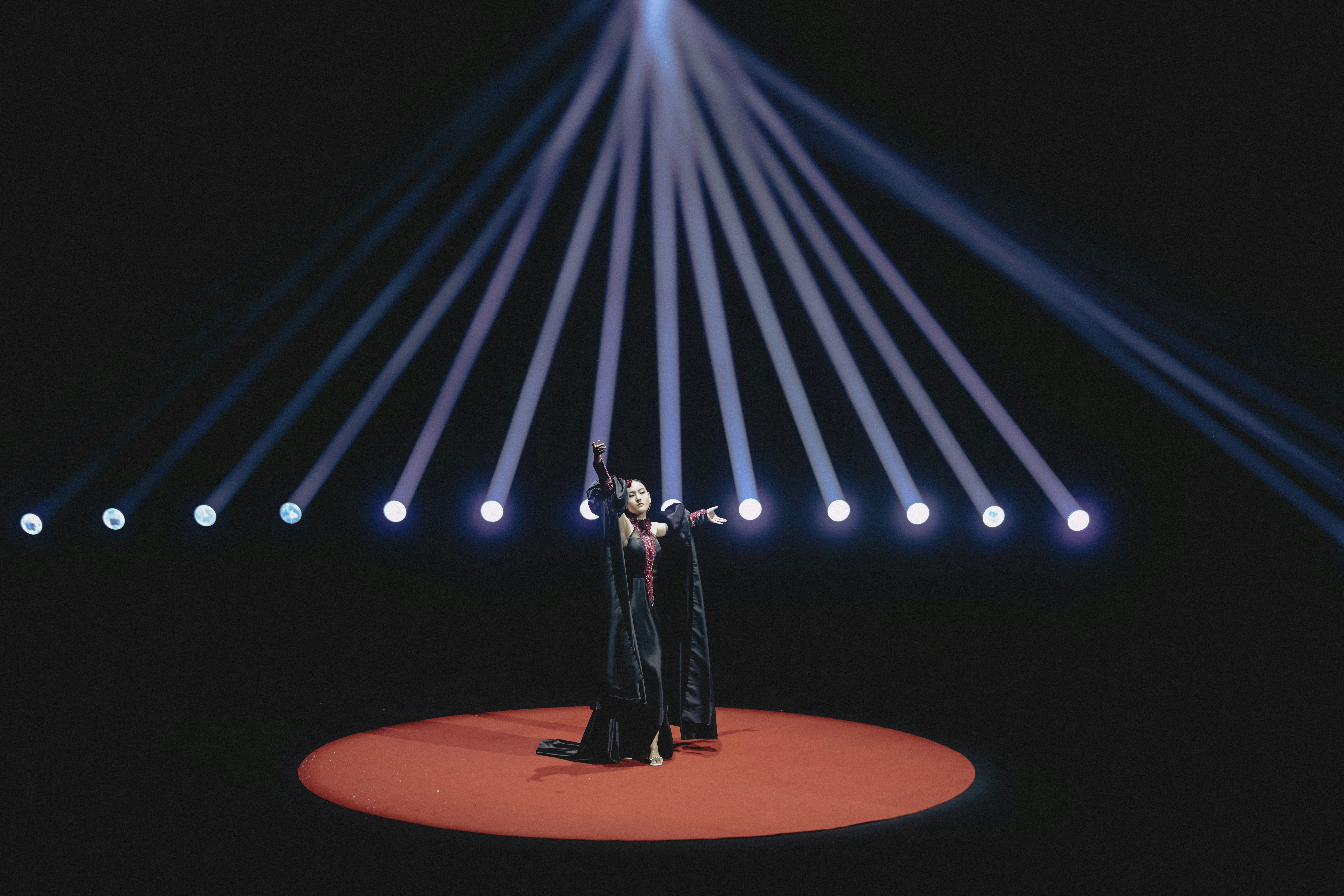 Spotlight Between Beams: A Solo Moment on a Red Circle Stage