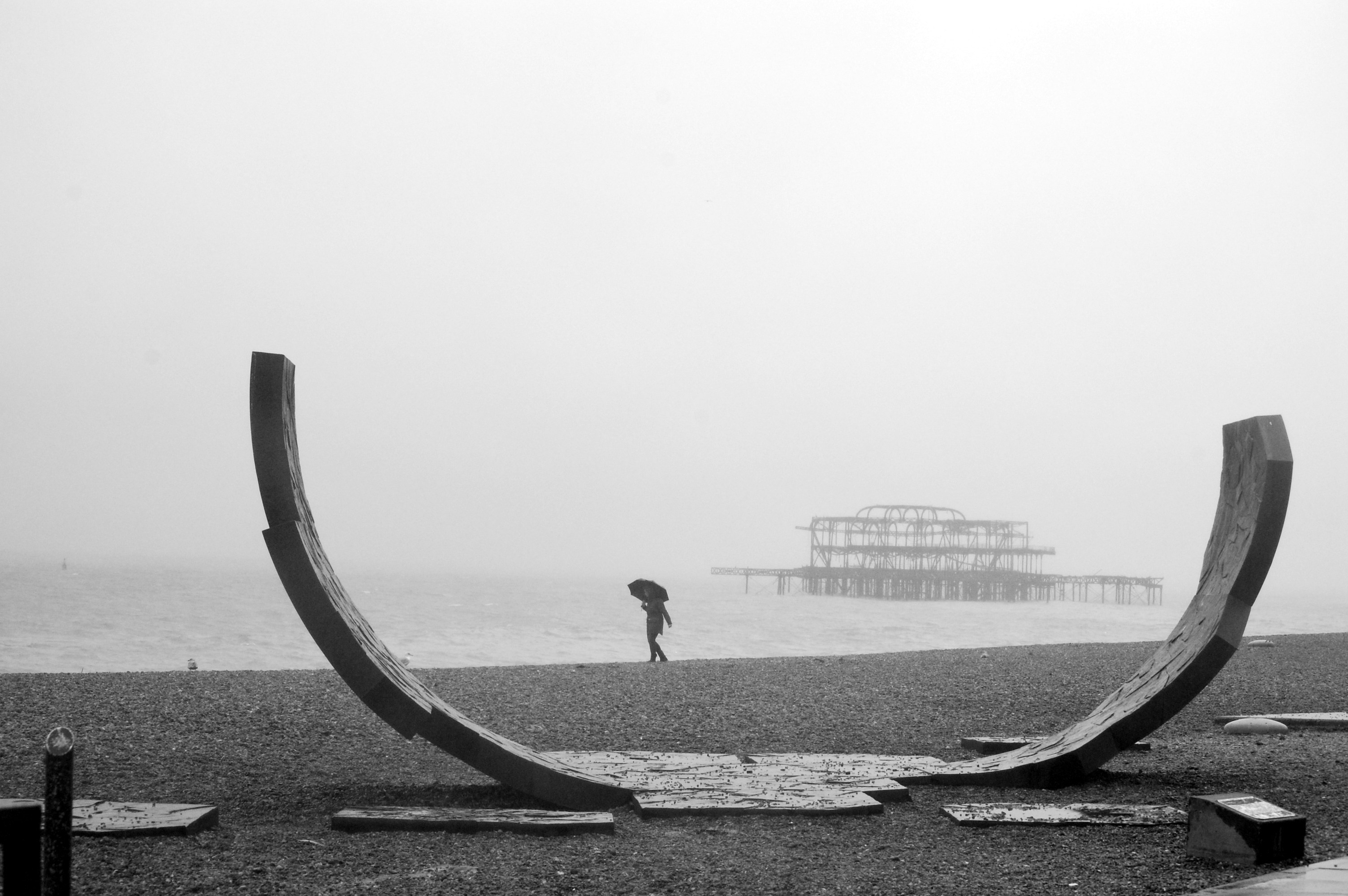 Curved Sentinels at the Shore: A Lone Jogger Beneath Rusted Promises