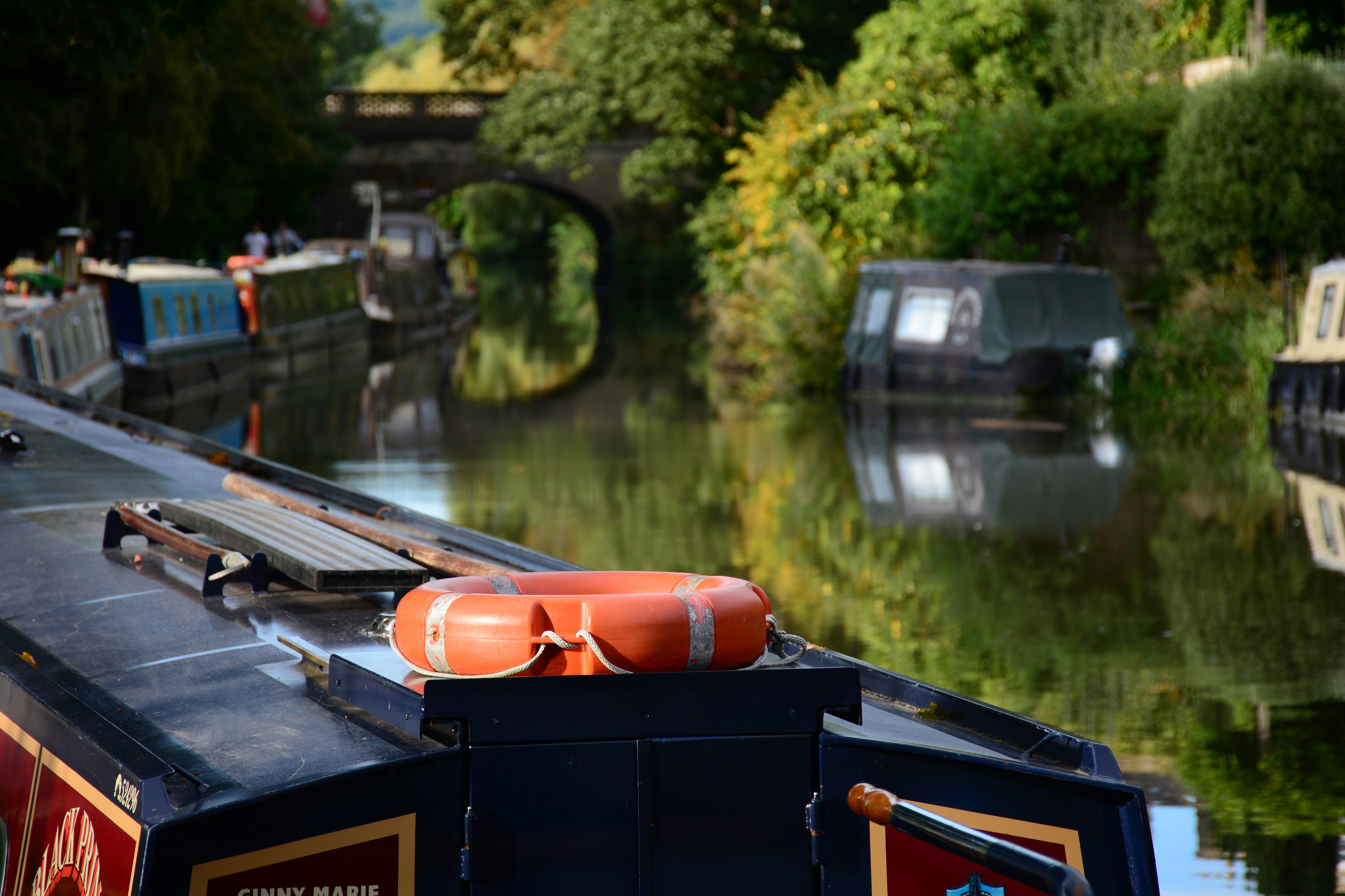 Orange Lifebuoy Secures the Bow in a Quiet Canal Morning