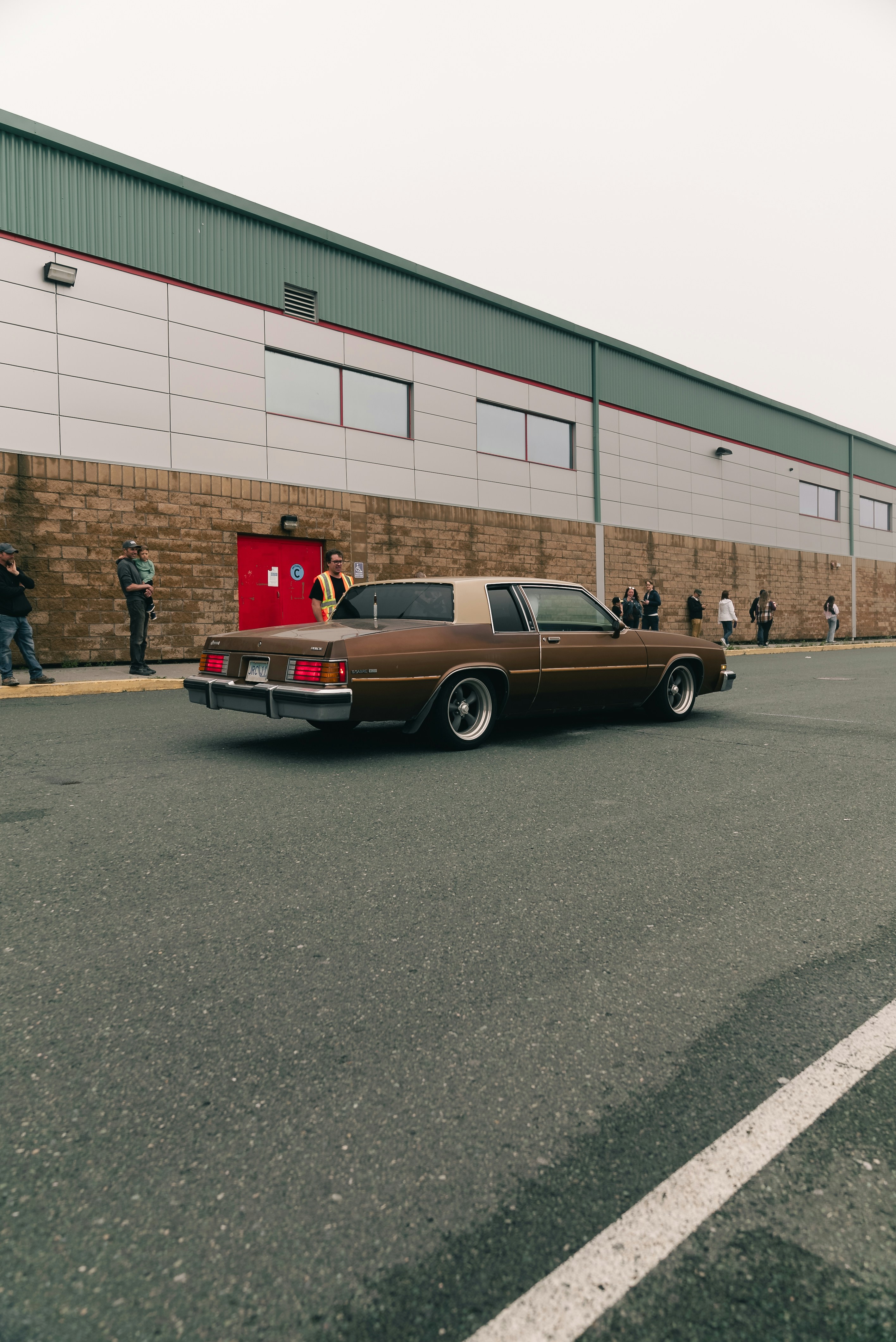 Vintage Crown: A Brown Classic Parked Before a Plain Facade