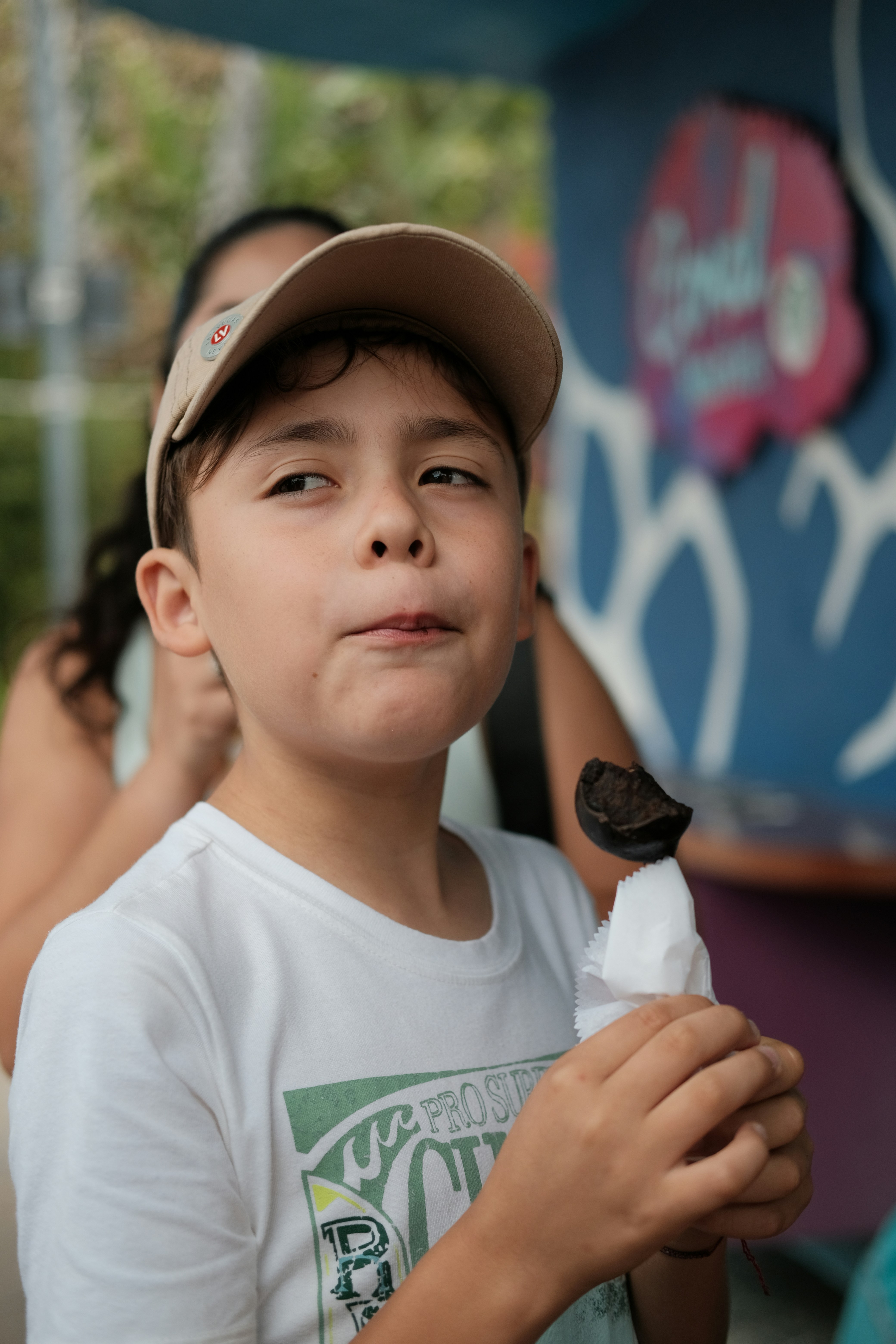 Close-Up of a Boy Enjoying a Chocolate Treat at a Muralside Stop