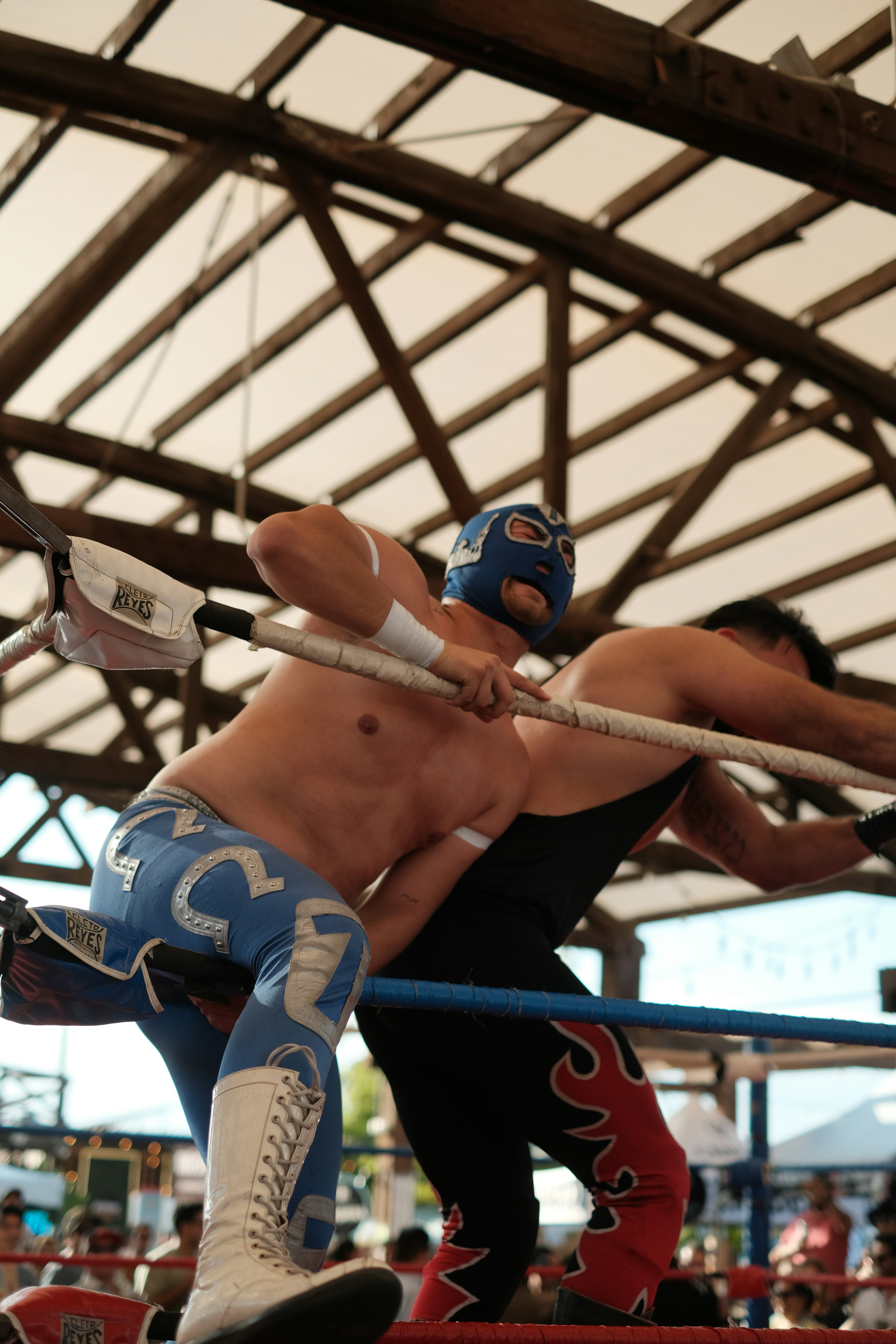 Ringside Clash: Wrestlers Straining in a Wooden Arena