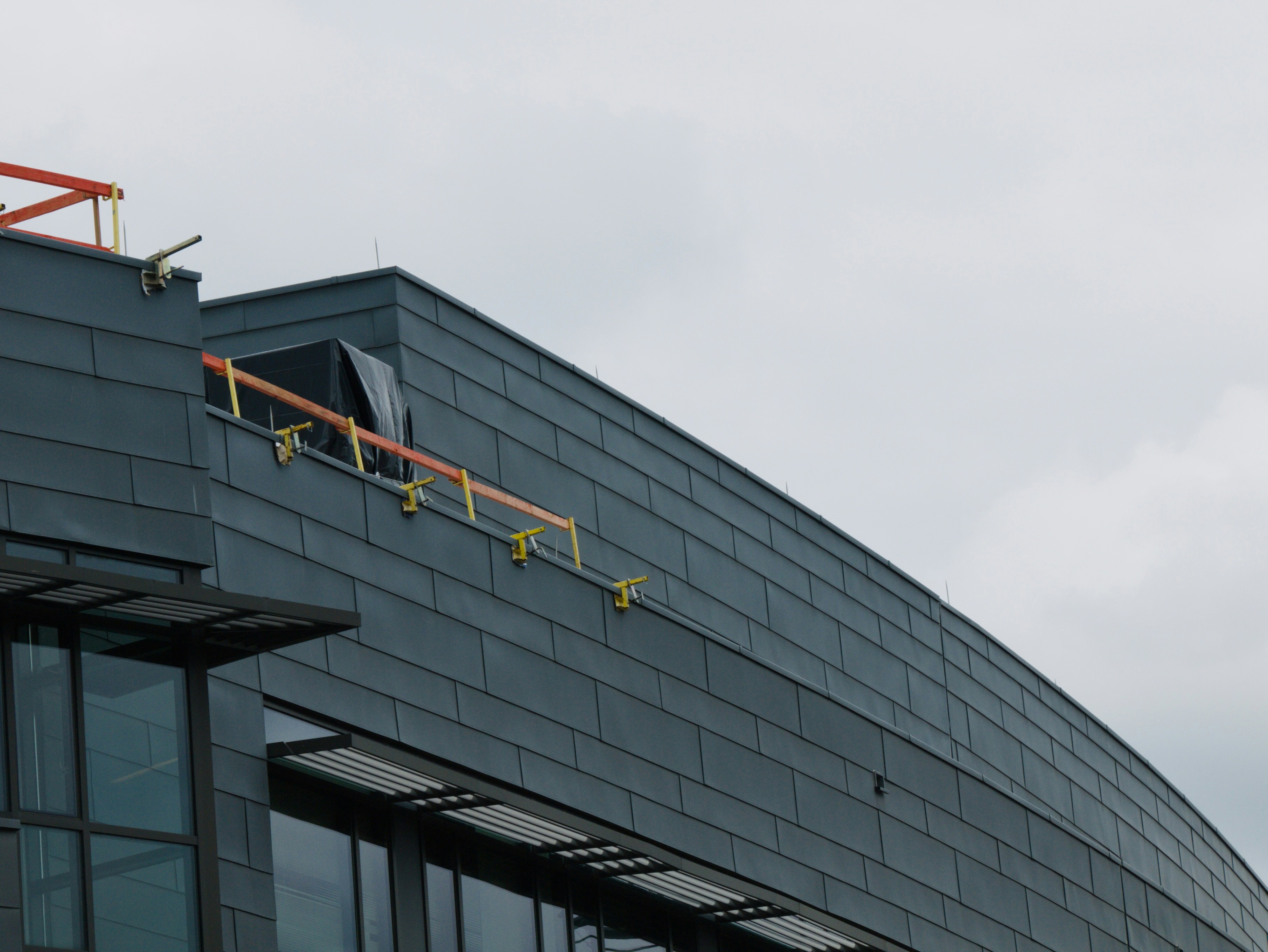 Urban Facade: A Modern Slate Building Under Stormy Skies