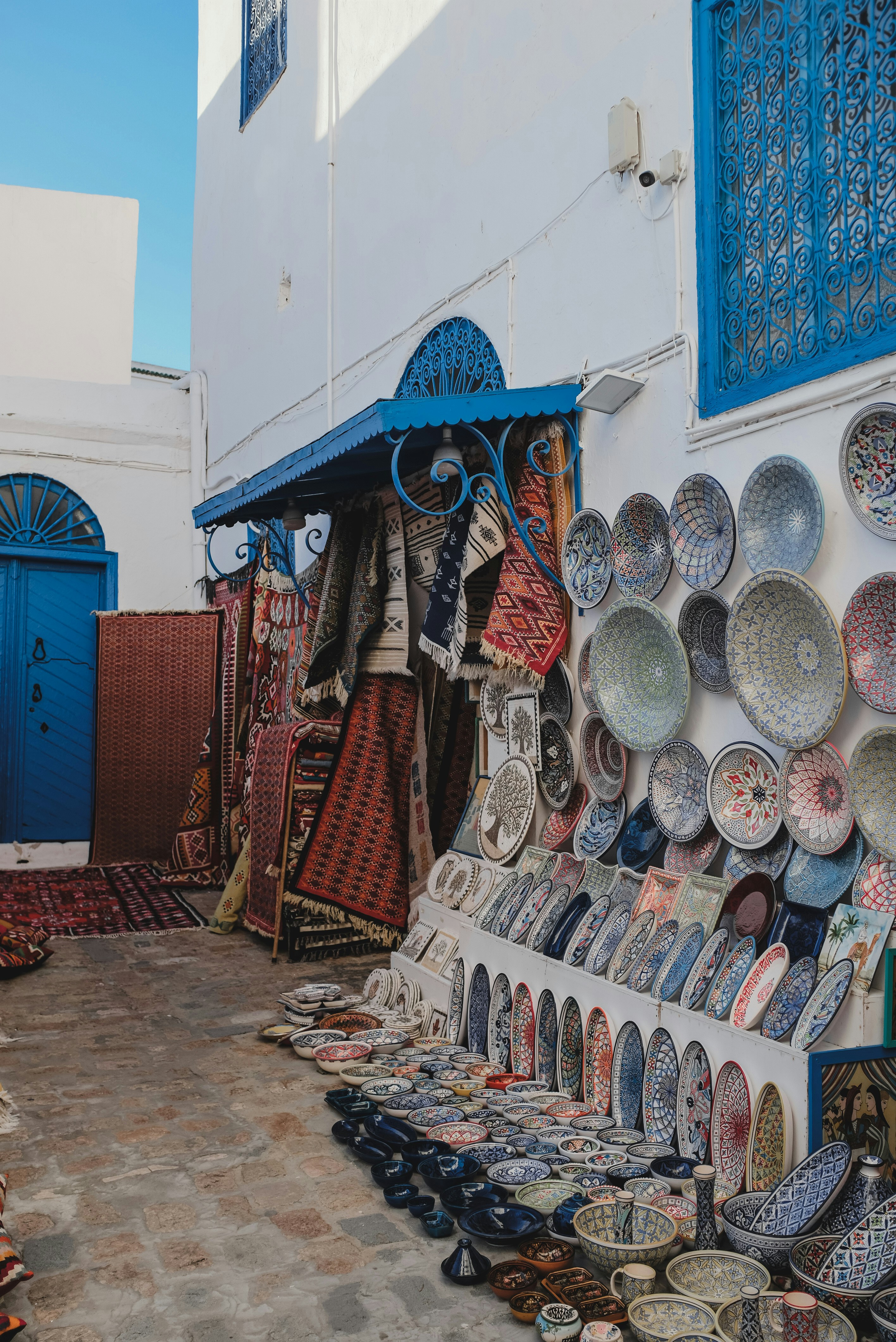 Blue-Walled Bazaar: A Courtyard of Plates and Weavings