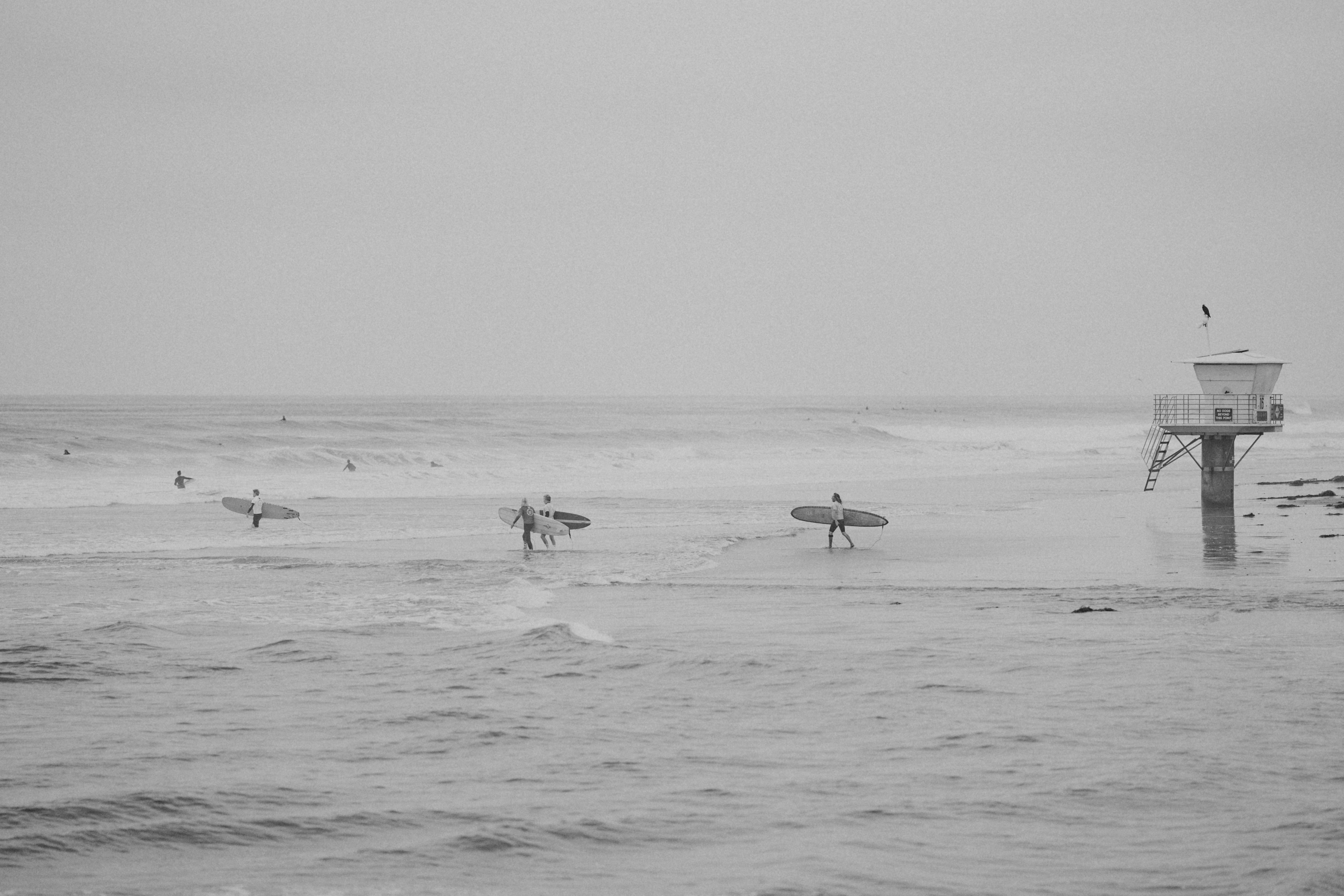 Surfers at Distant Break under a Quiet Overcast Sky